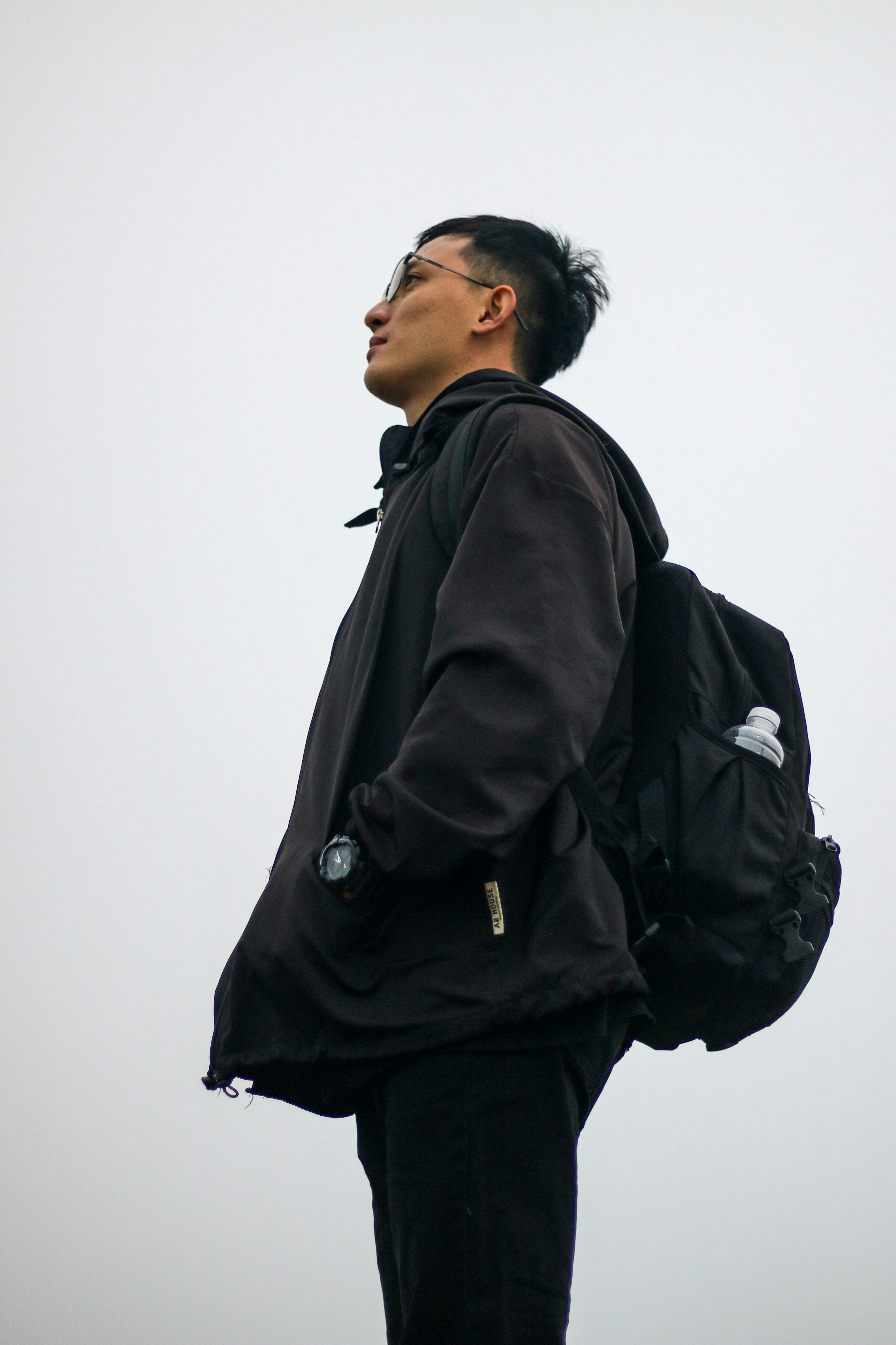 Young Man in Hooded Windbreaker Jacket Posing Outdoors · Free Stock Photo