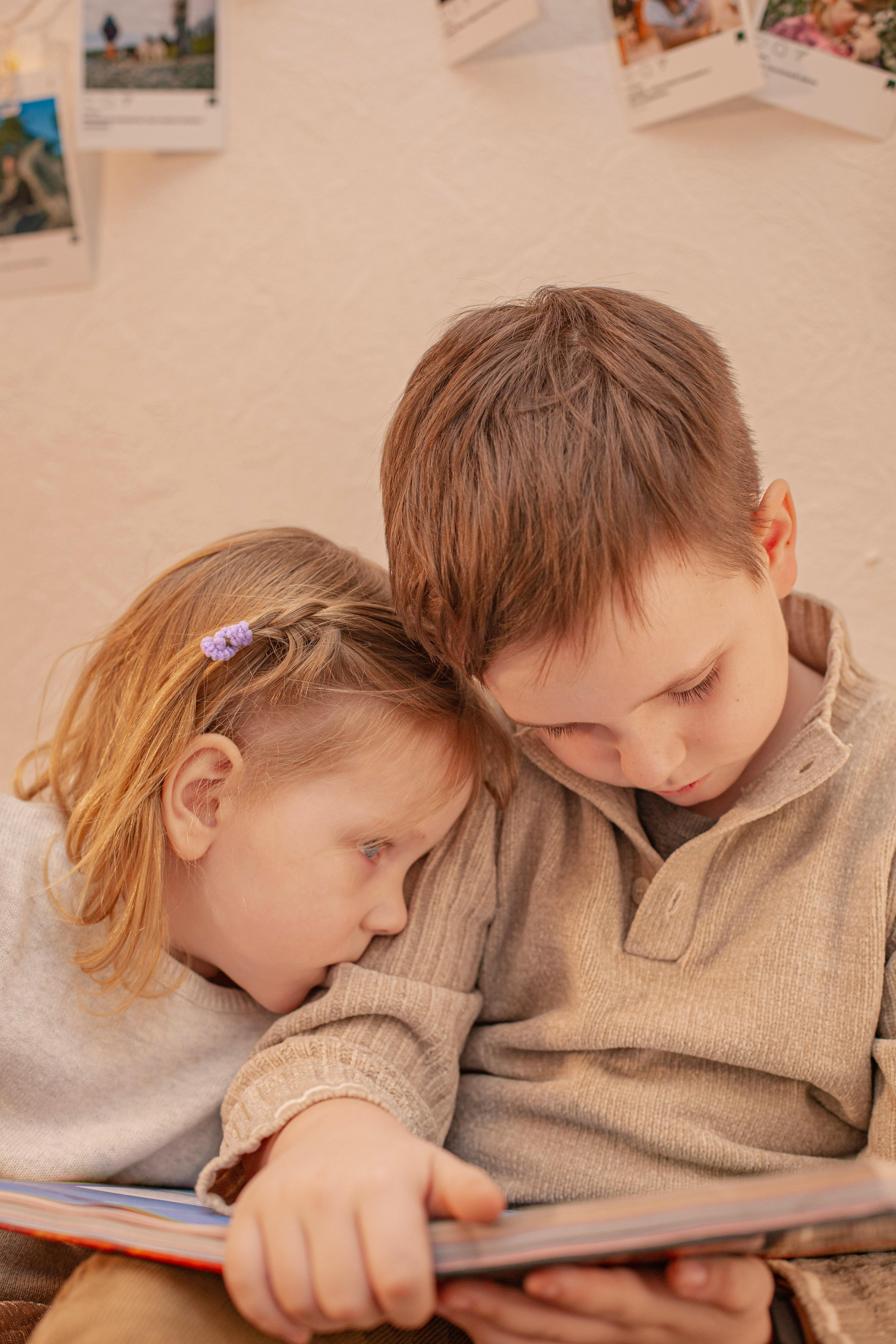 Siblings Reading a Book Together · Free Stock Photo