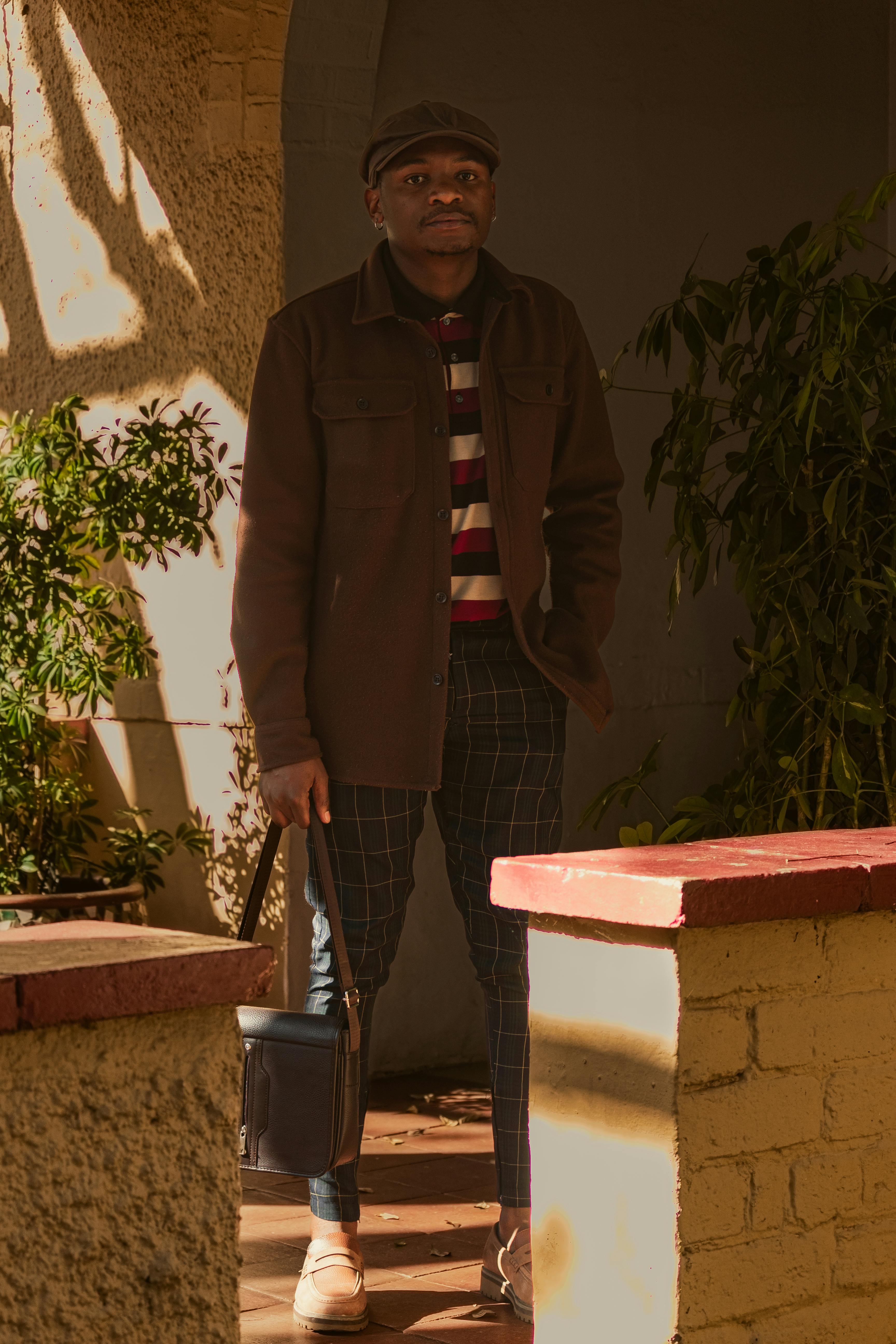 Man in Hat Posing by Wall · Free Stock Photo