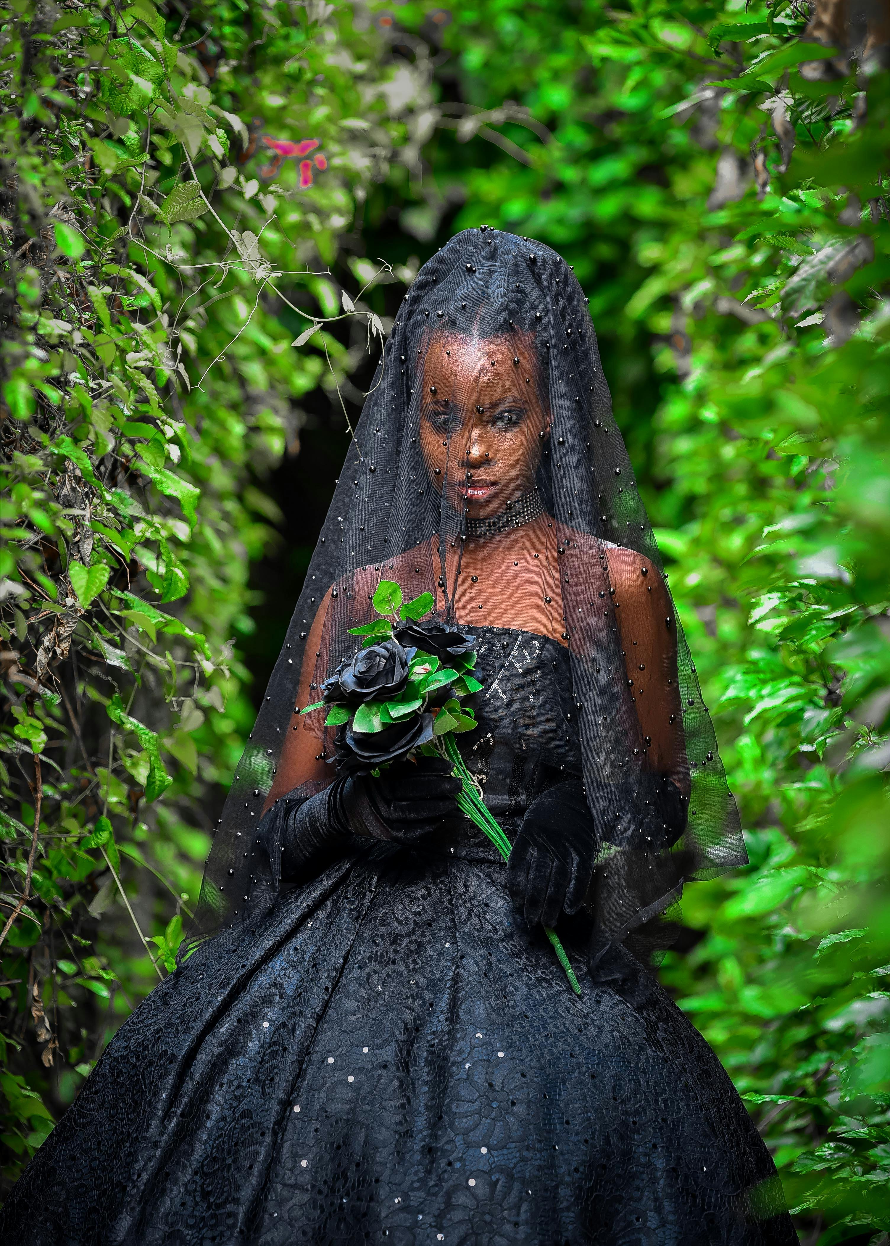 Woman in Black Dress Holding Black Roses · Free Stock Photo