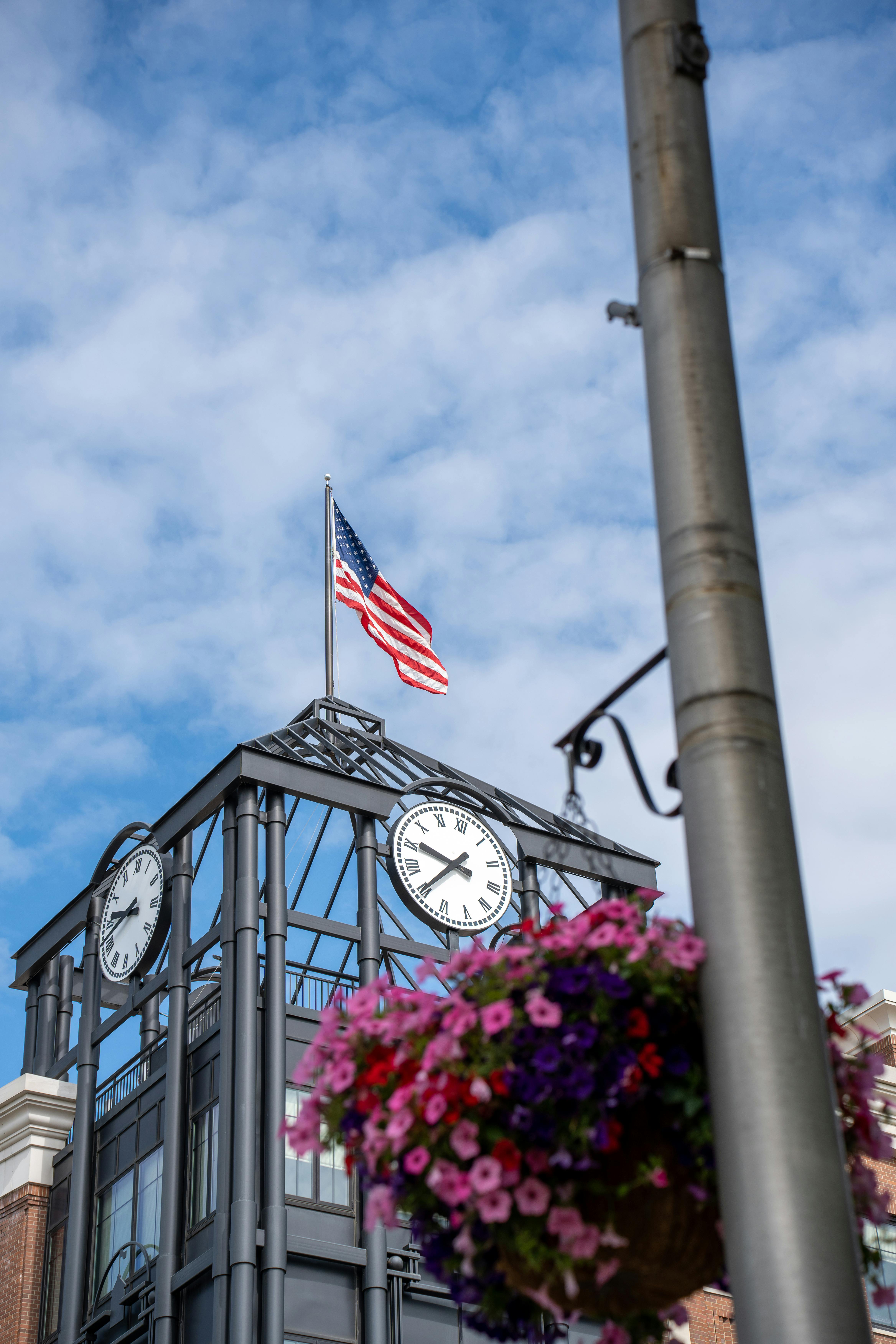 American Flag over Building with Clocks · Free Stock Photo