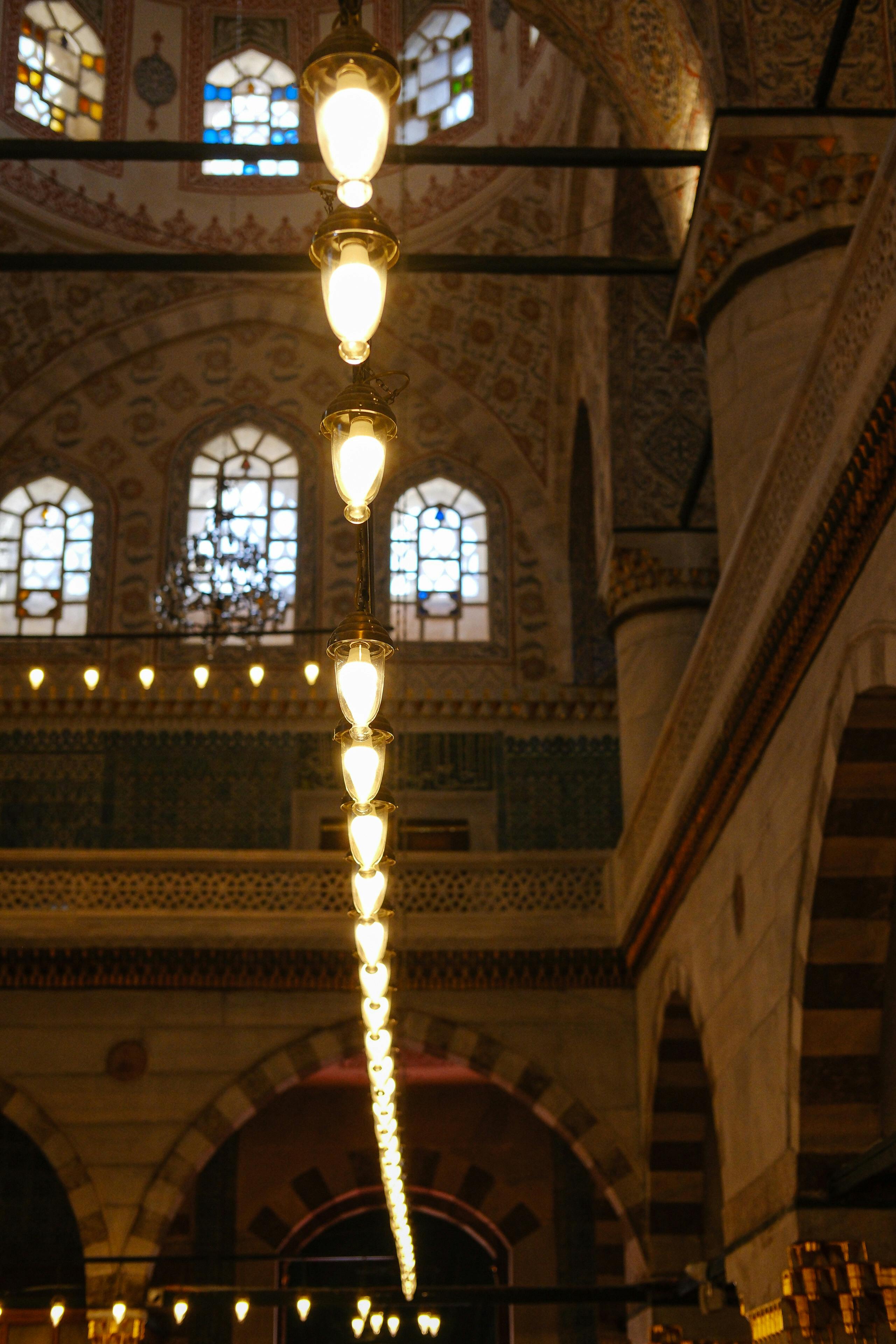 The interior of a mosque with many lights · Free Stock Photo