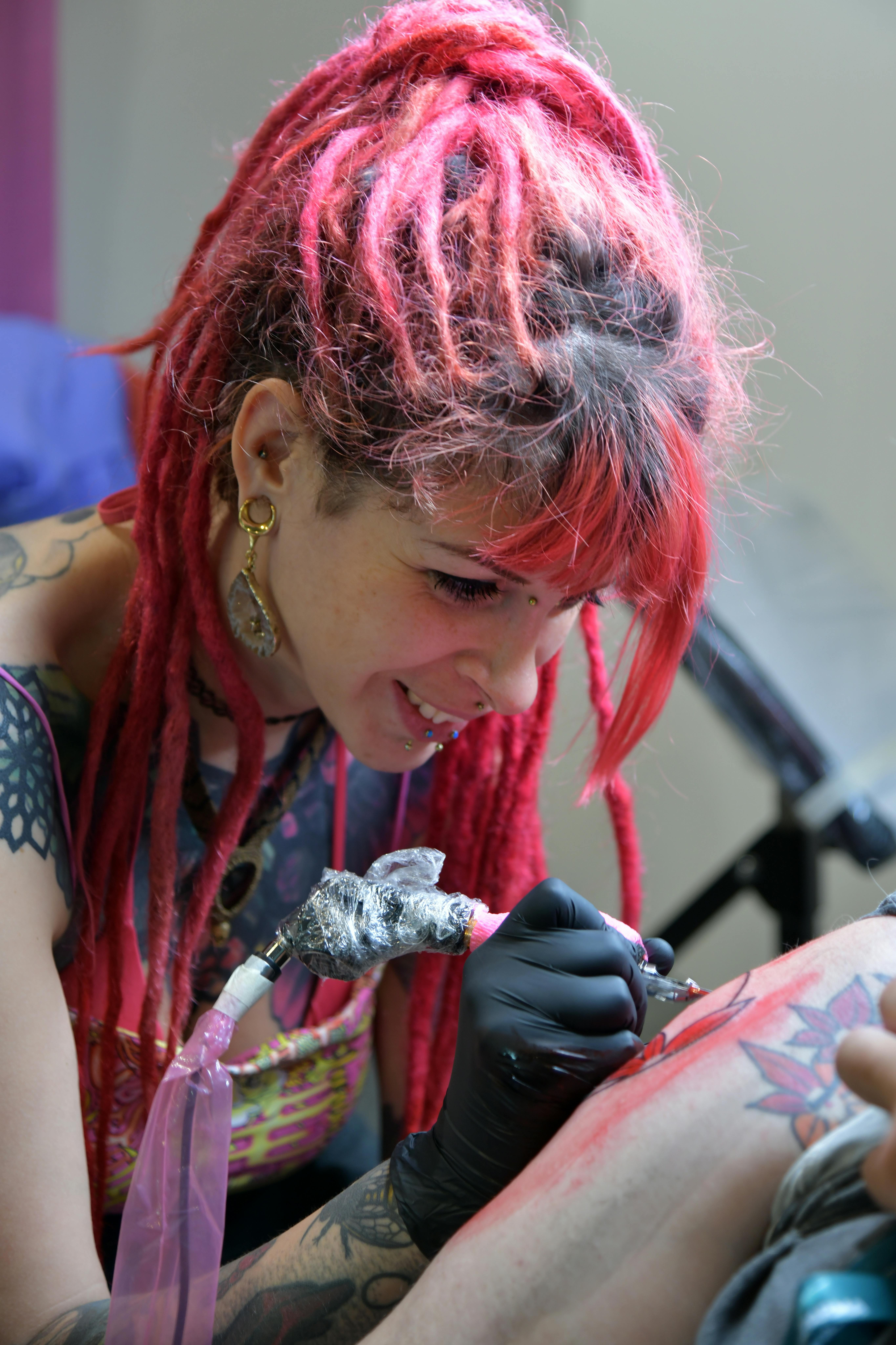 Tattooist with Dreadlocks Doing a Tattoo · Free Stock Photo