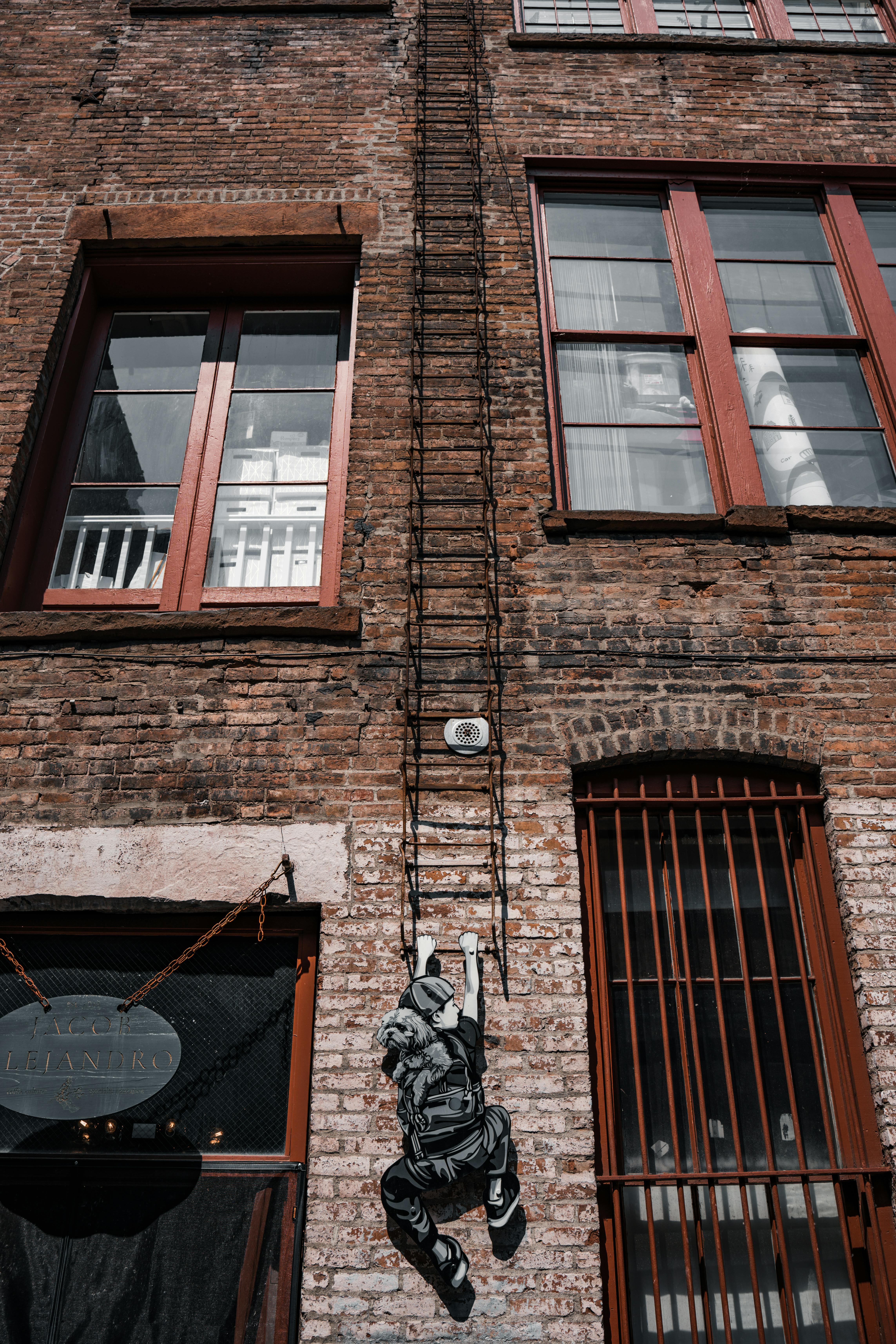A sculpture of a man climbing a building · Free Stock Photo
