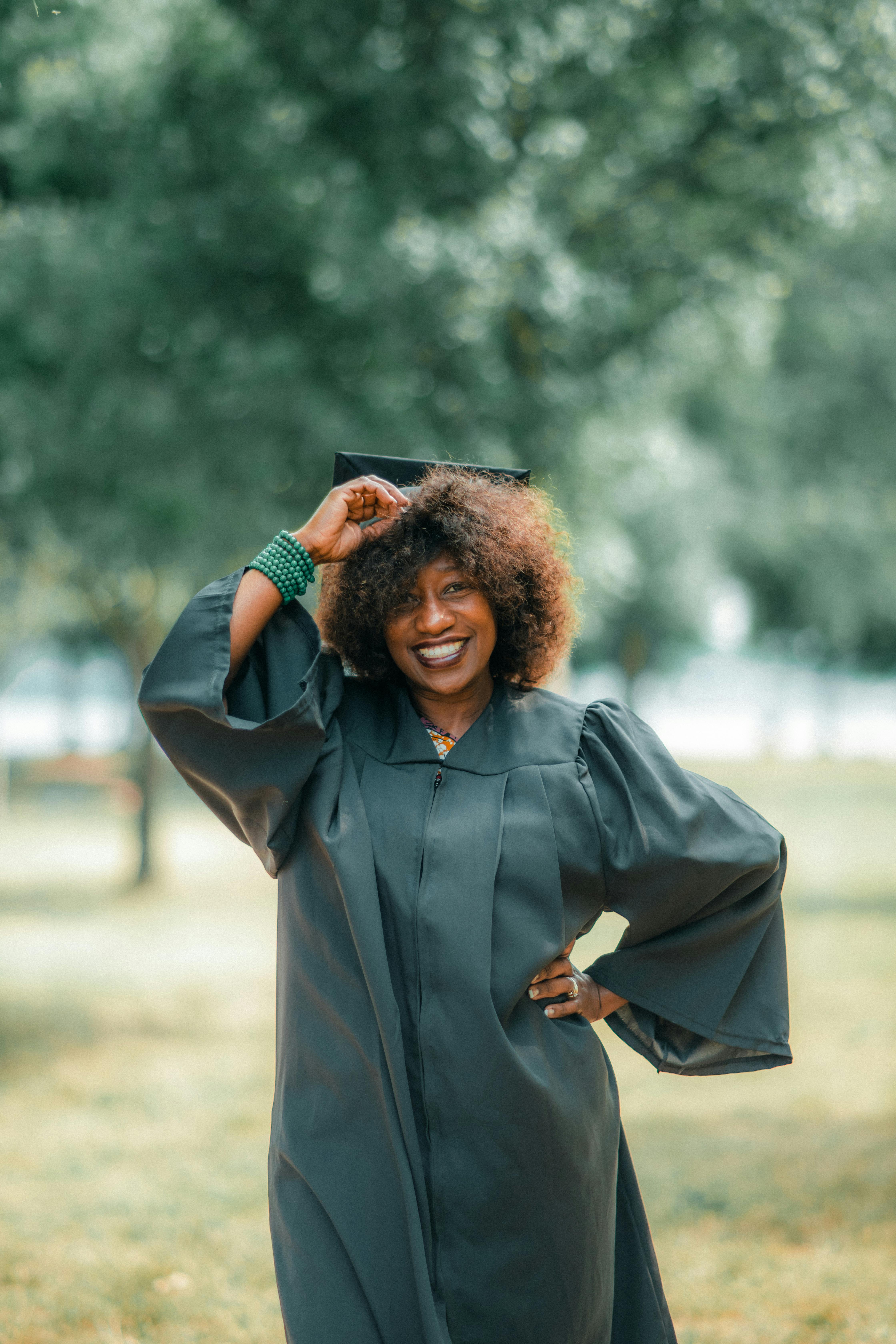 Woman in a Graduation Gown Standing with her Hand on Hip · Free Stock Photo