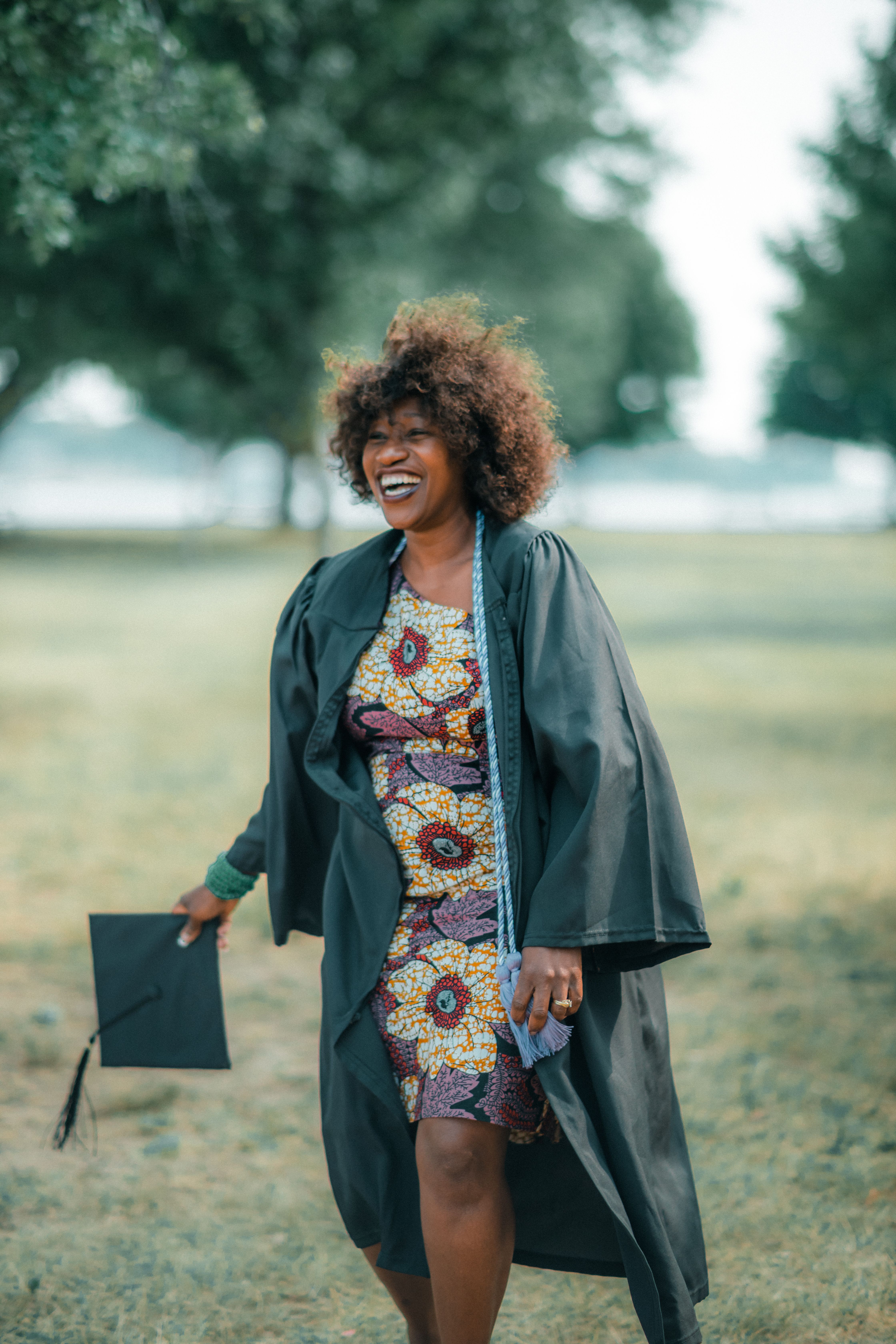 Woman in a Graduation Gown with a Hat in her Hand · Free Stock Photo
