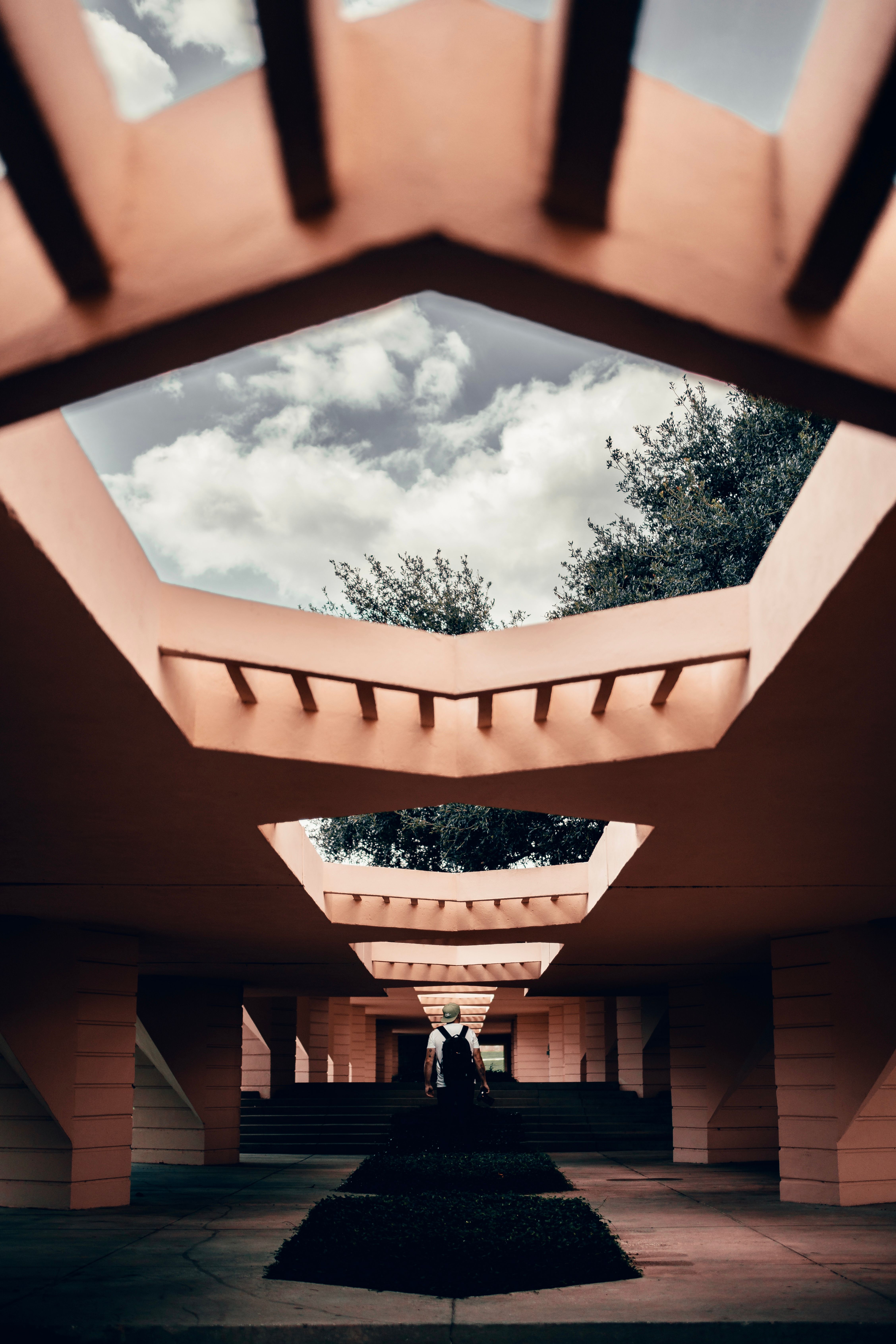 Man Standing under Beams in Shadow · Free Stock Photo
