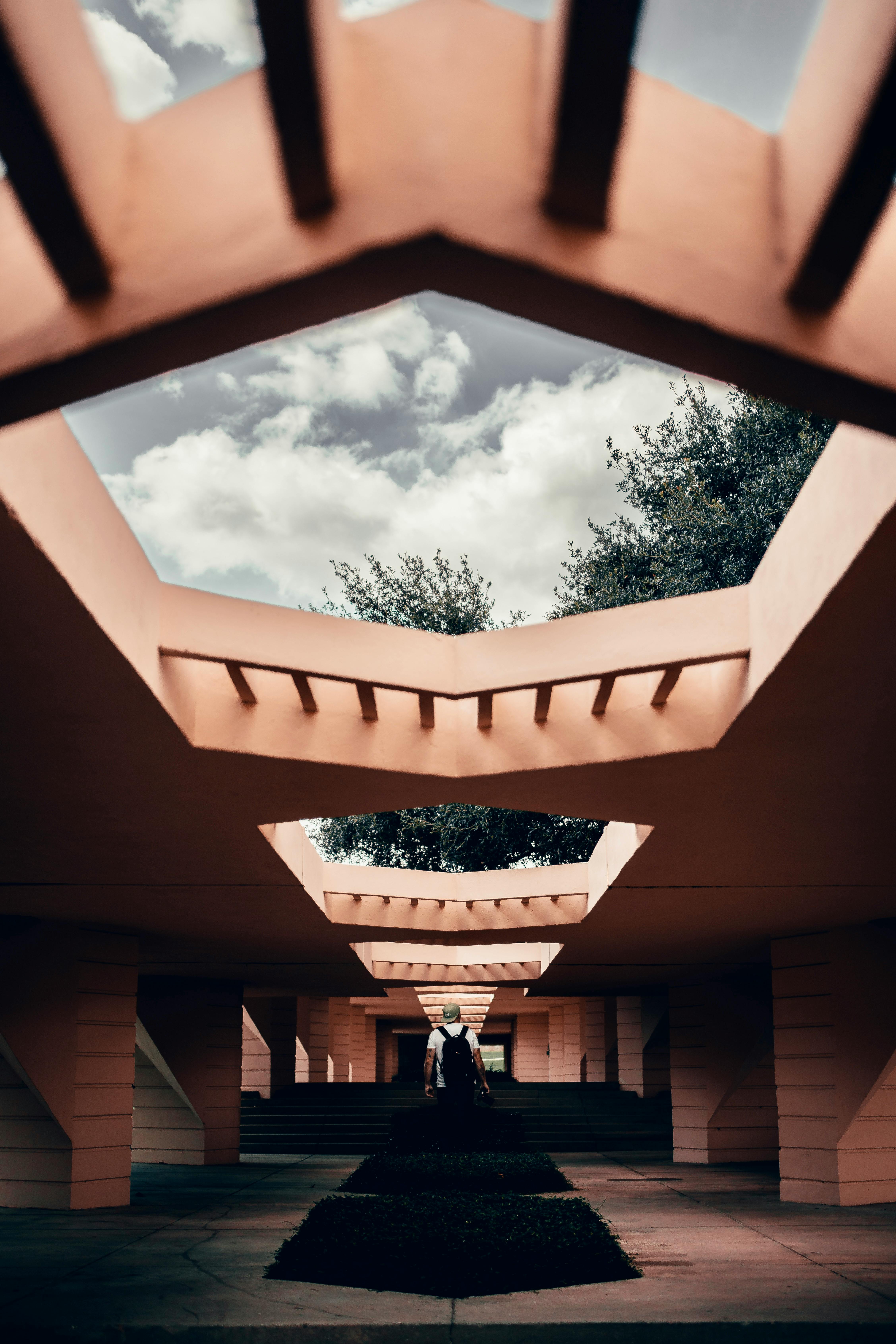 Man Standing under Beams in Shadow · Free Stock Photo