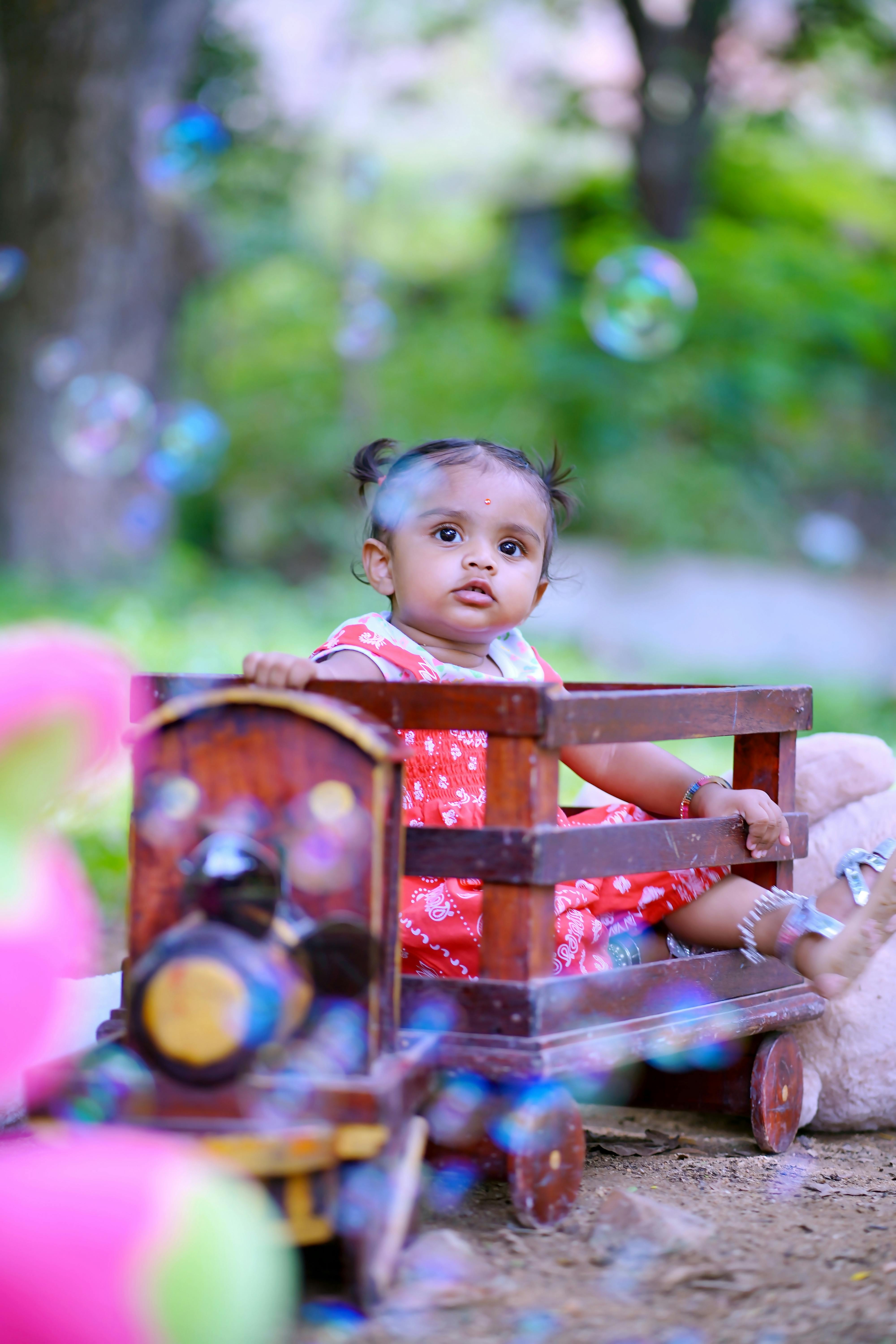 A Baby Girl Sitting on the Garden Tulips · Free Stock Photo