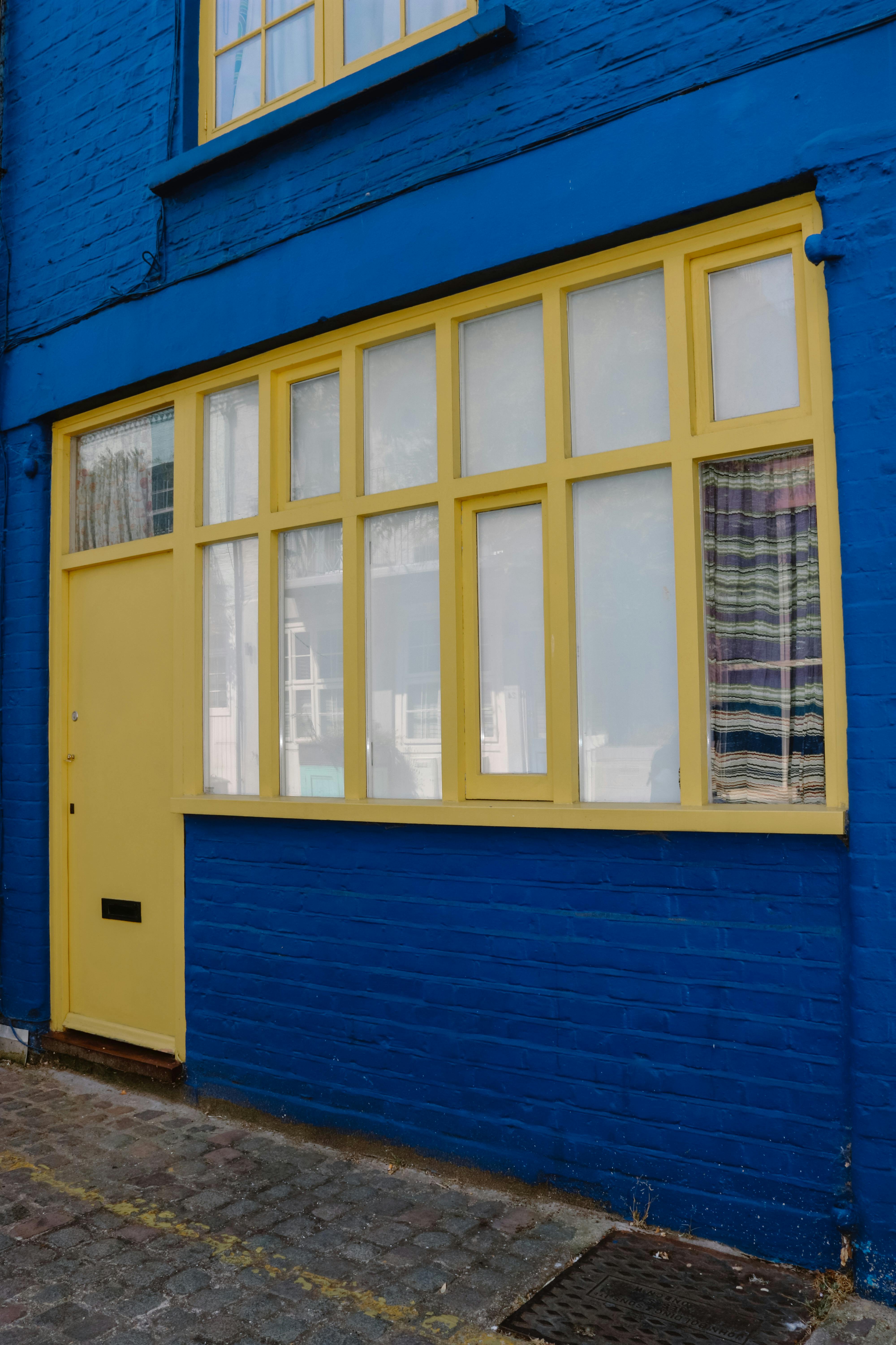 Yellow Window Frame and Door of a Blue Colored Old Brick House · Free ...