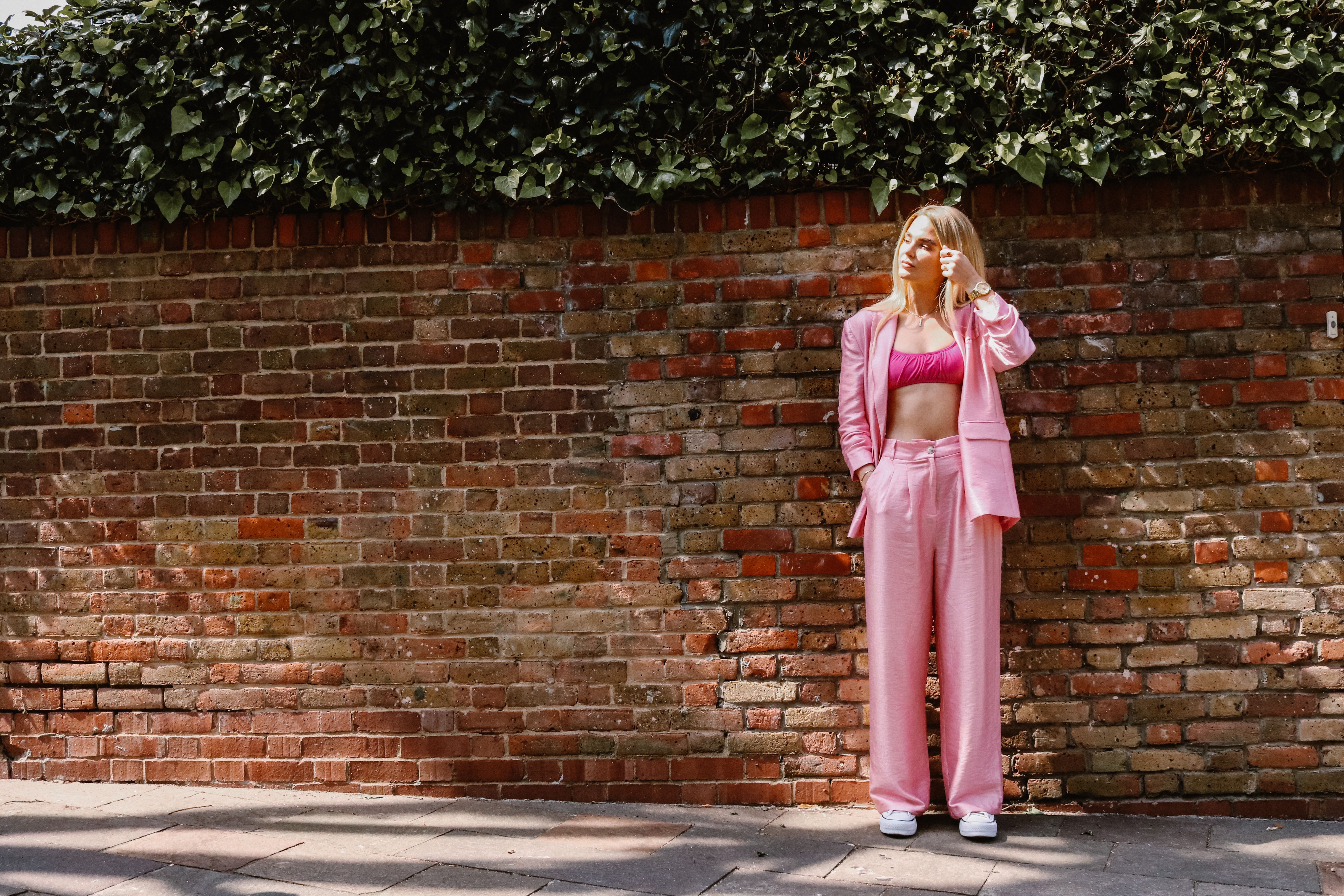 Woman in Pink Clothes Posing by Wall · Free Stock Photo