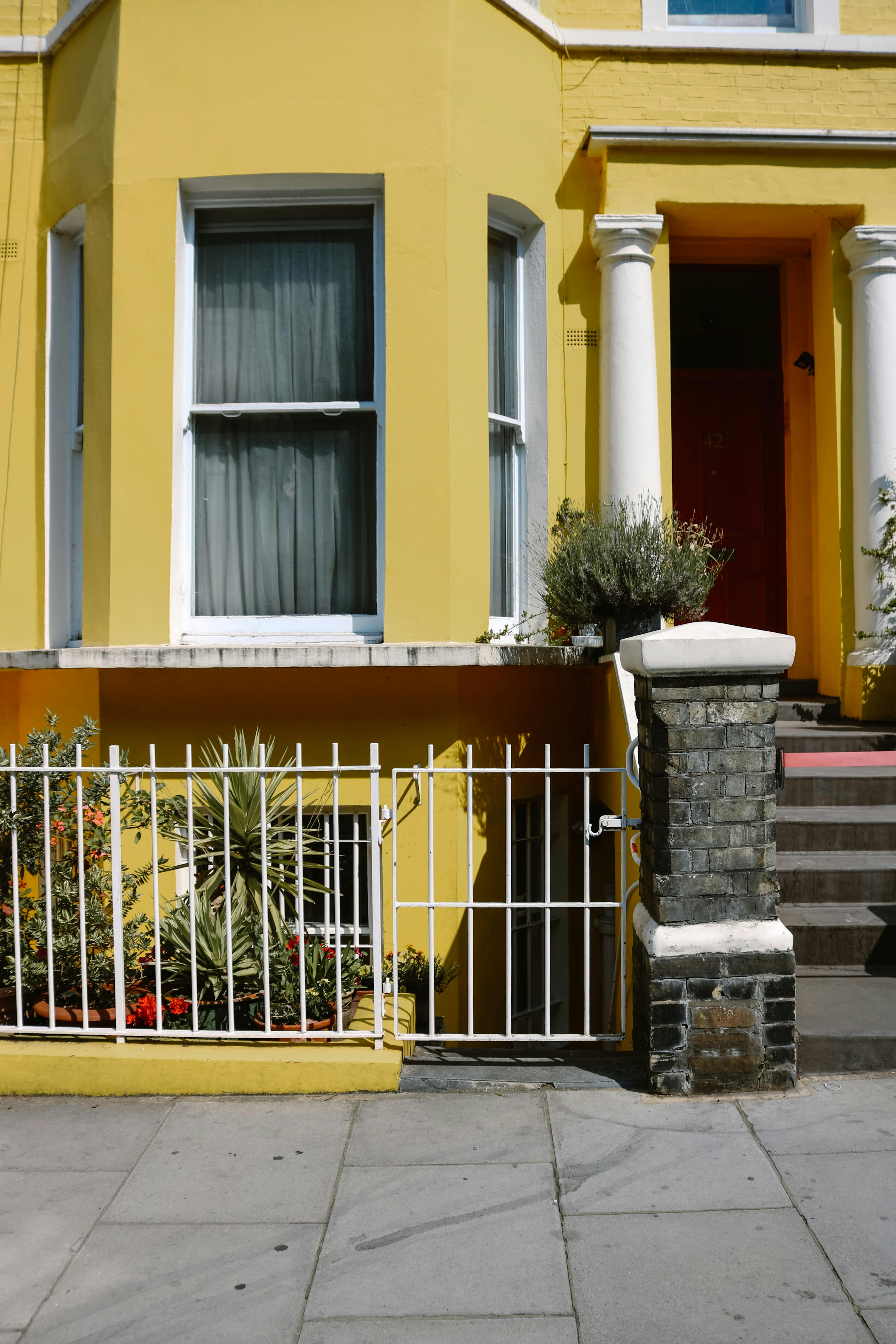 Sidewalk near House Wall and Fence · Free Stock Photo