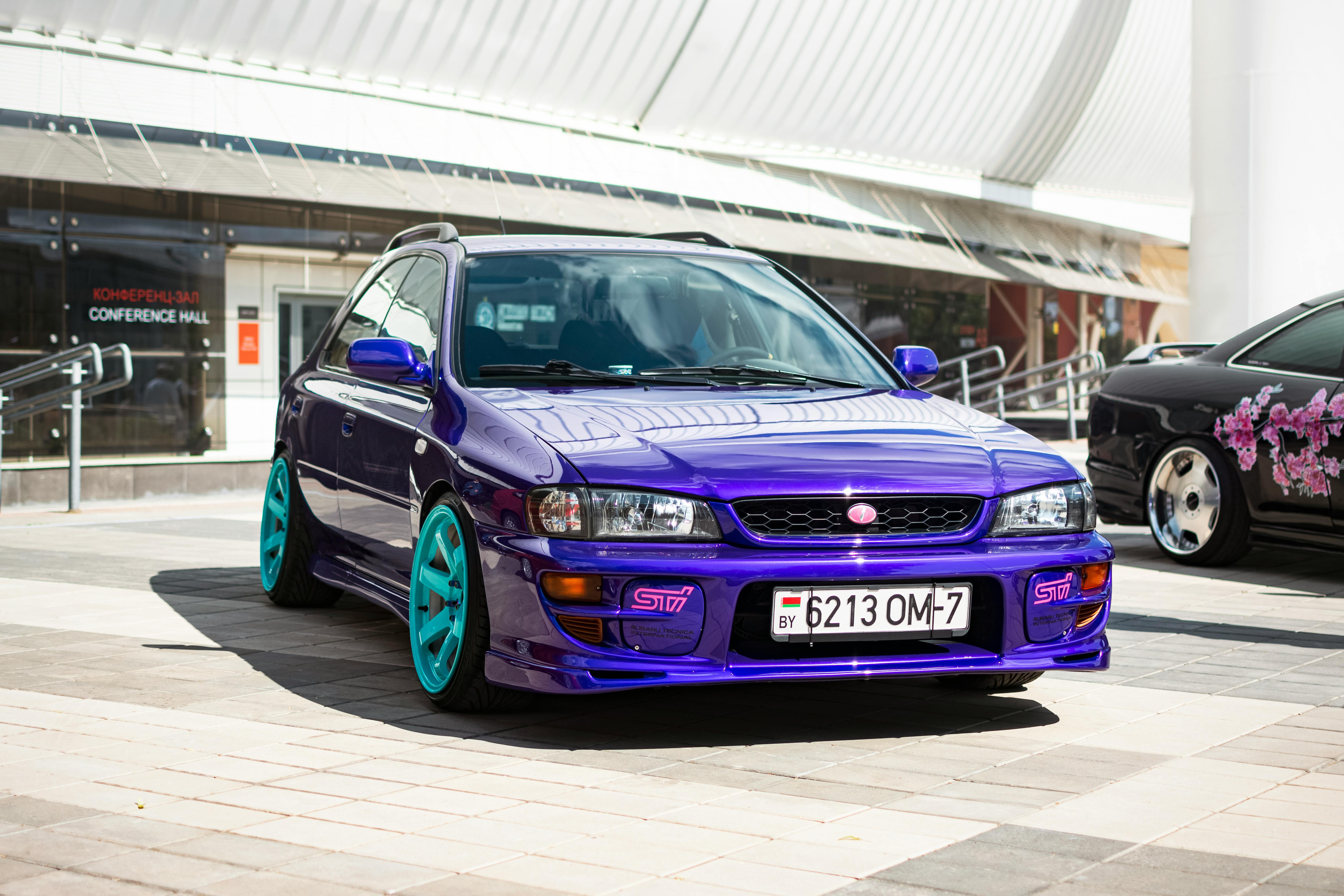 Purple Car with Turquoise Wheels Parked on a Pavement · Free Stock Photo