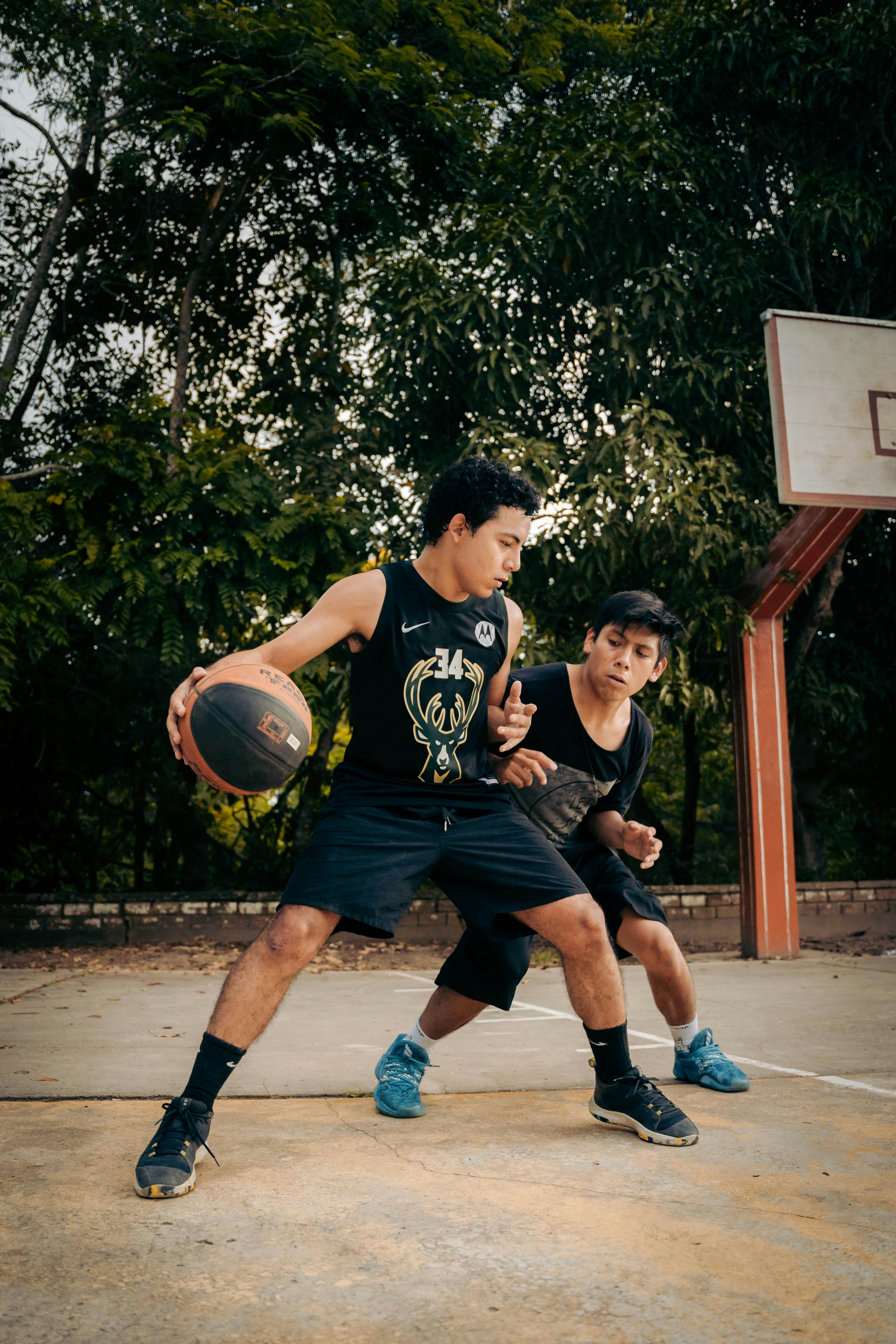 Delighted multiethnic friends playing basketball in park · Free Stock Photo