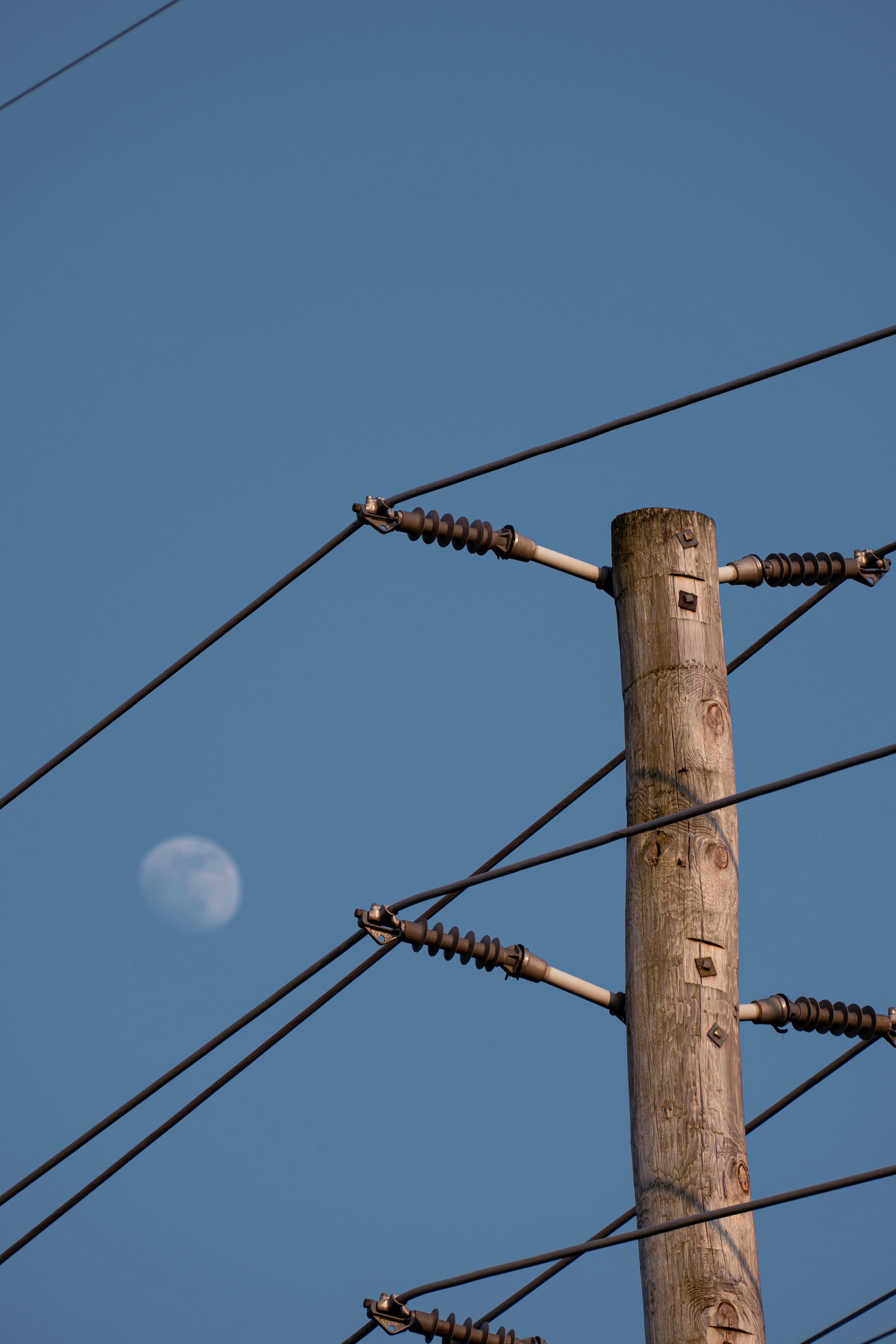 Post with Electrical Cables against Blue Sky with Moon · Free Stock Photo