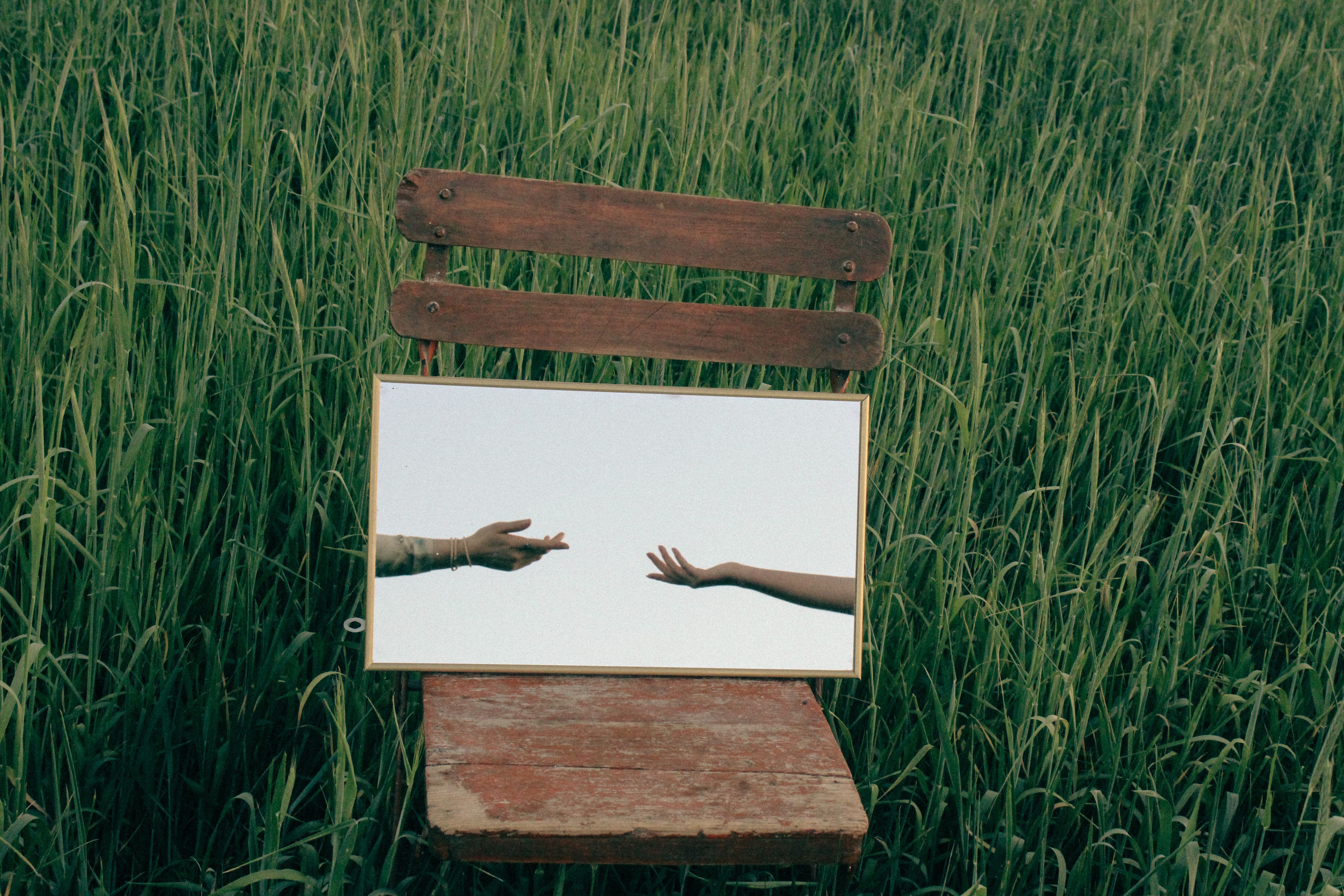 Picture of Reaching Hands on an Old Chair Among Tall Green Grass · Free ...