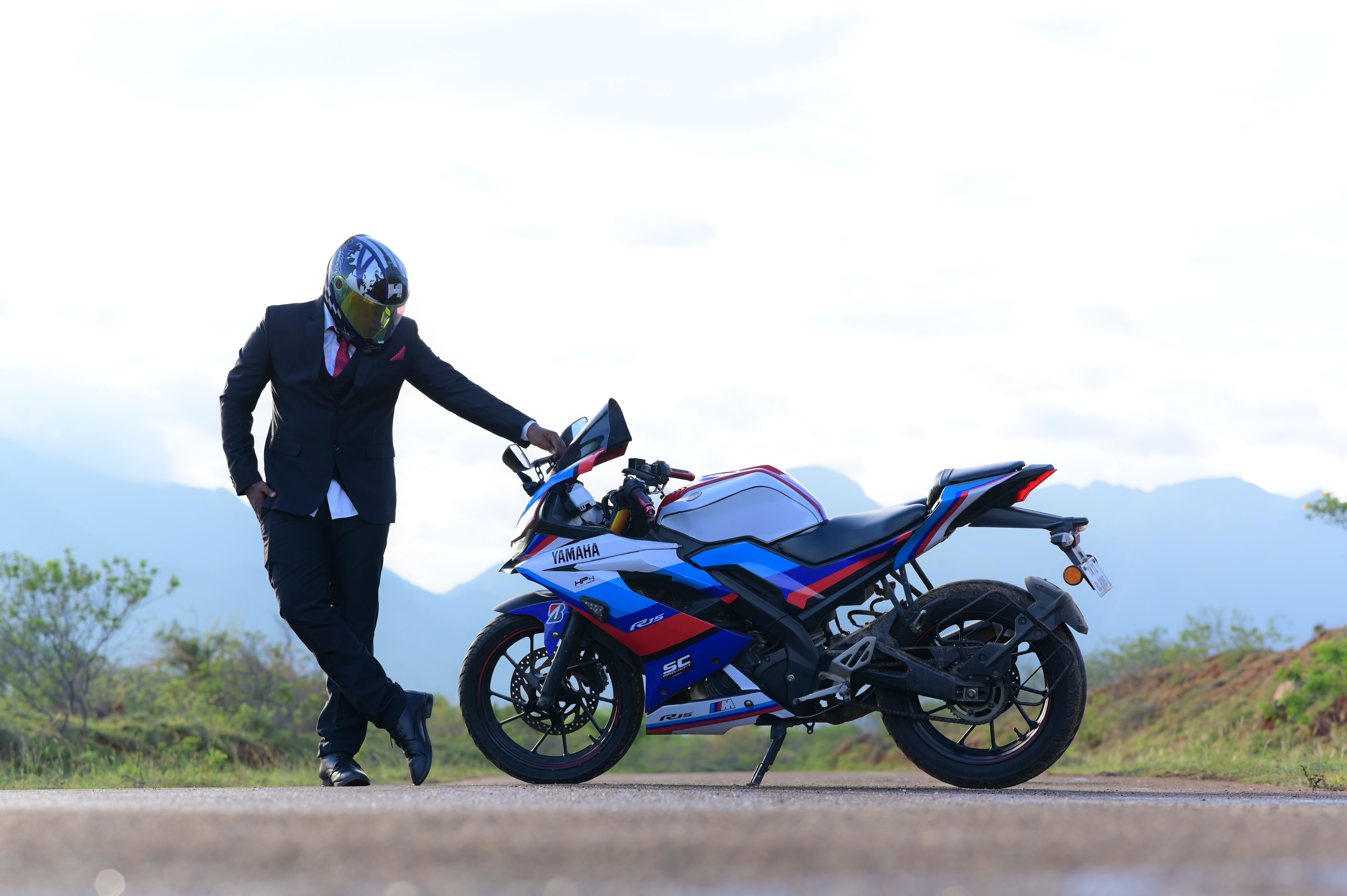 Man in Suit Standing with Yamaha Motorbike on Road · Free Stock Photo