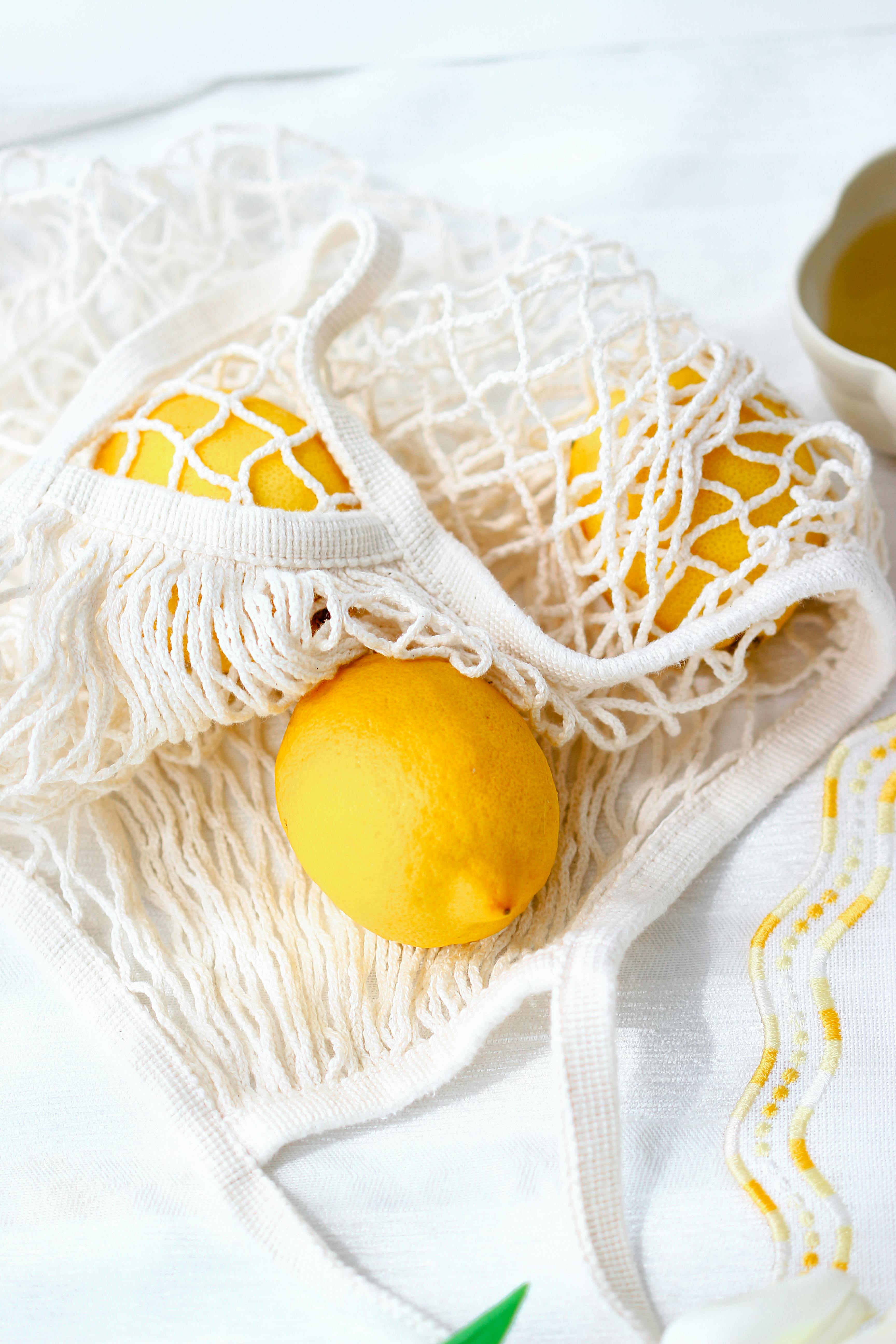 Hand Holding Net Bag with Lemons · Free Stock Photo