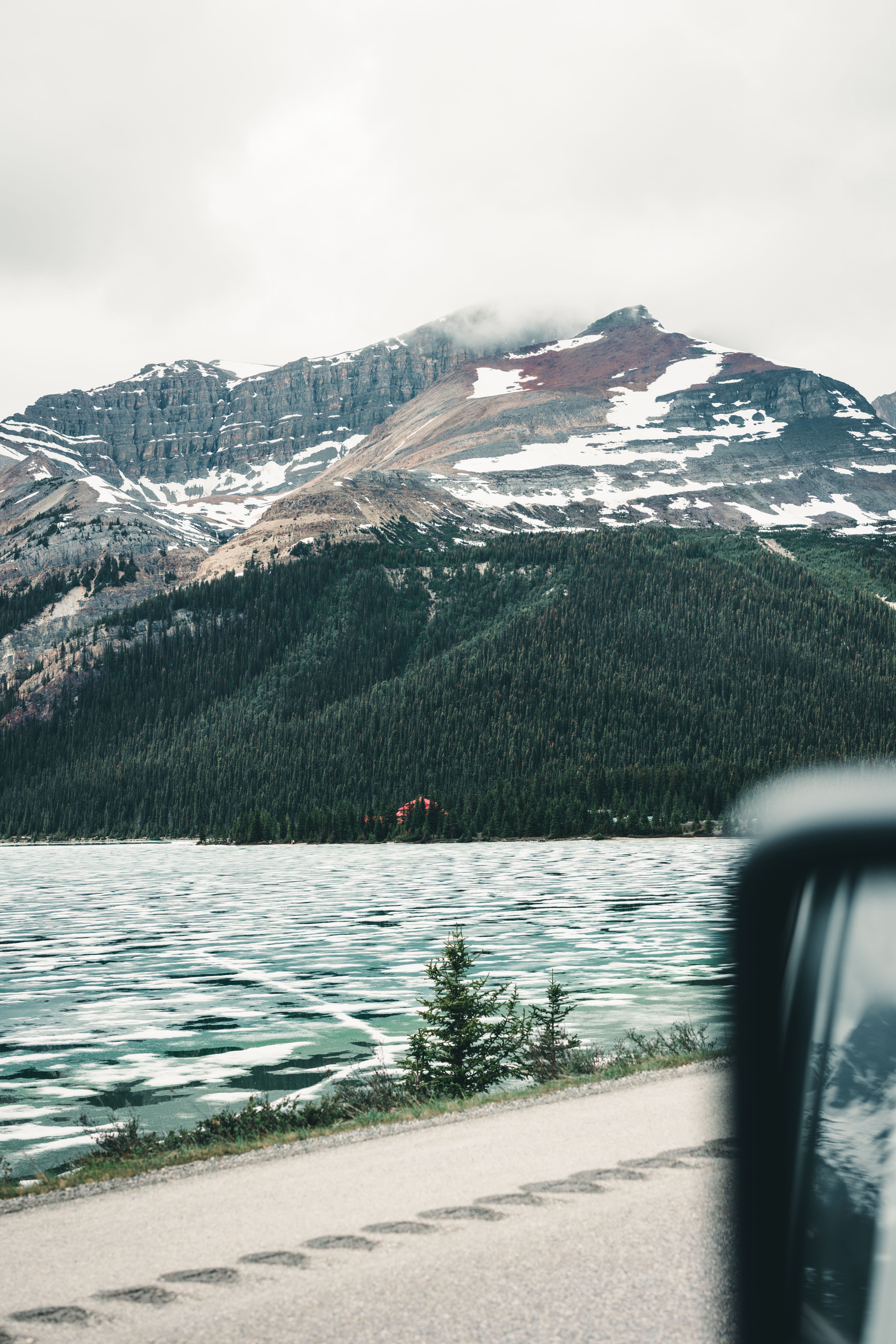 A car is driving along a road with mountains in the background · Free ...