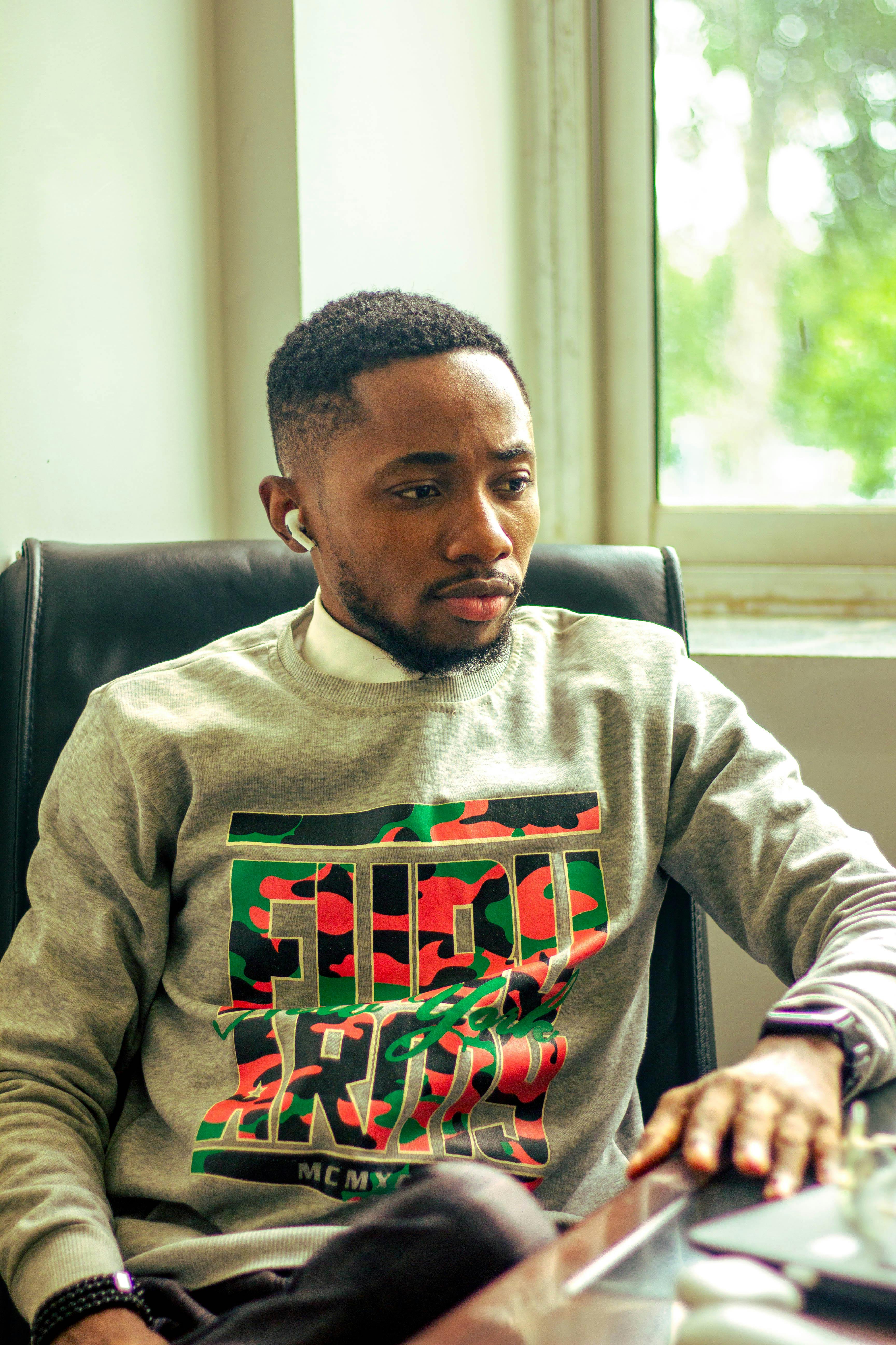 Young Man Sitting on Street Curb and Vaping · Free Stock Photo