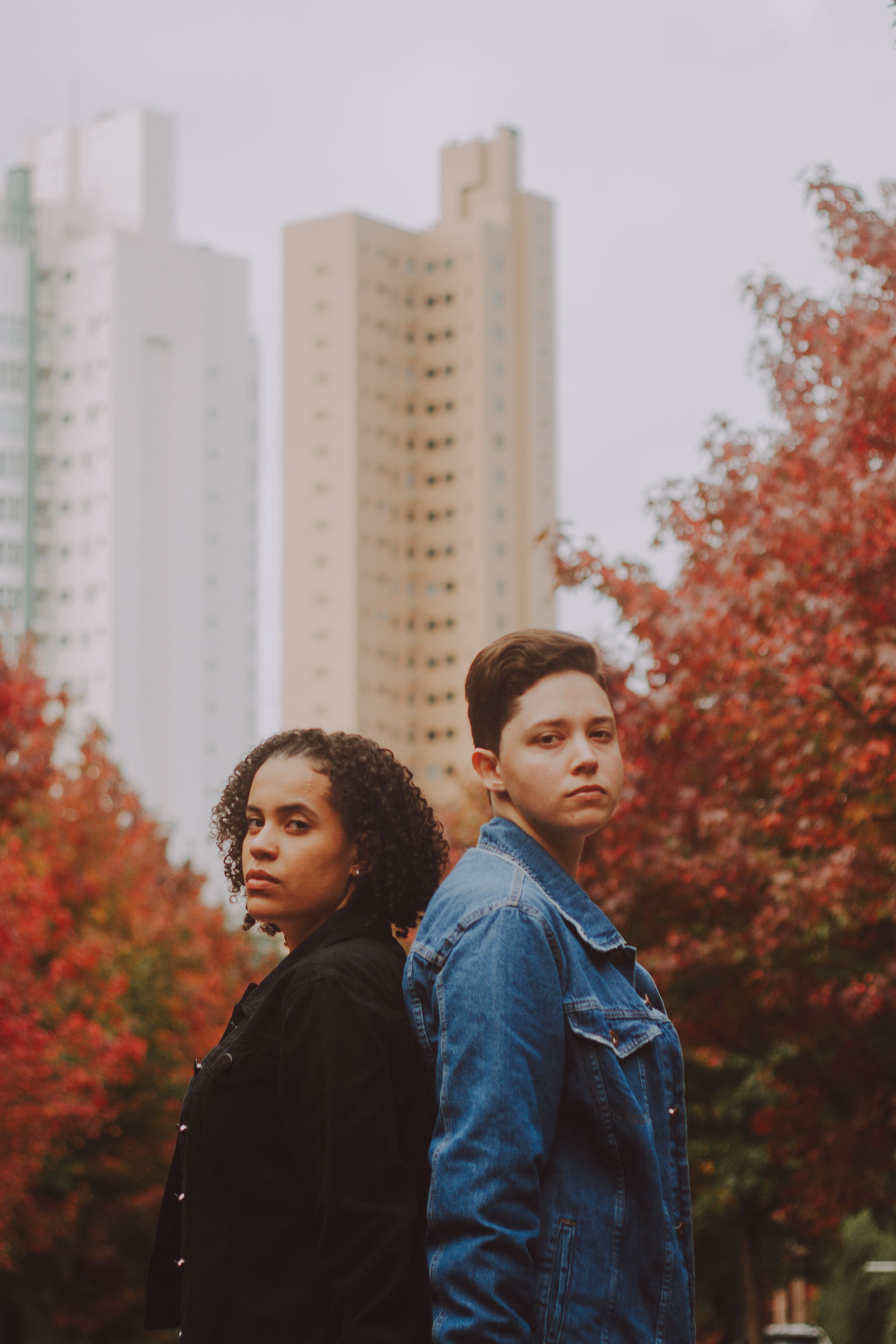 Woman and Man Posing Back to Back in Park · Free Stock Photo