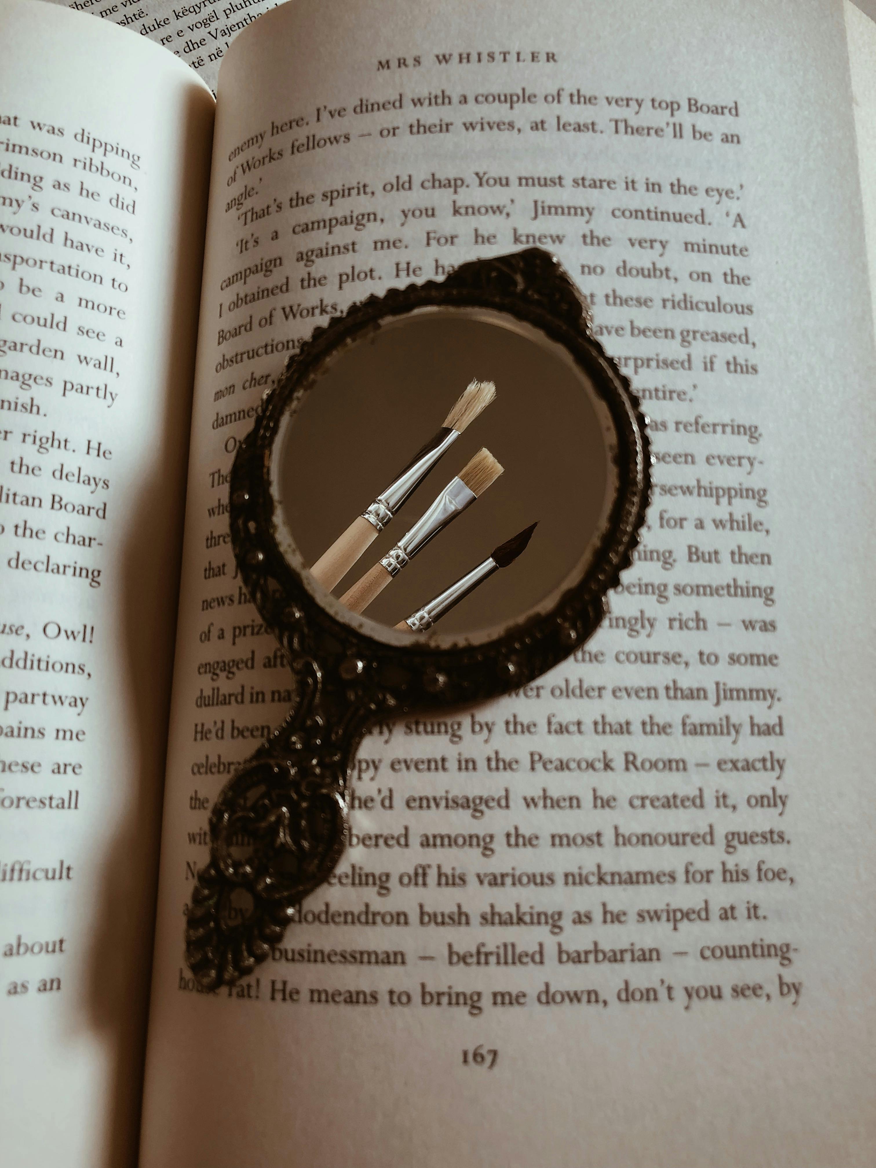 Mirror Lying on Open Book · Free Stock Photo