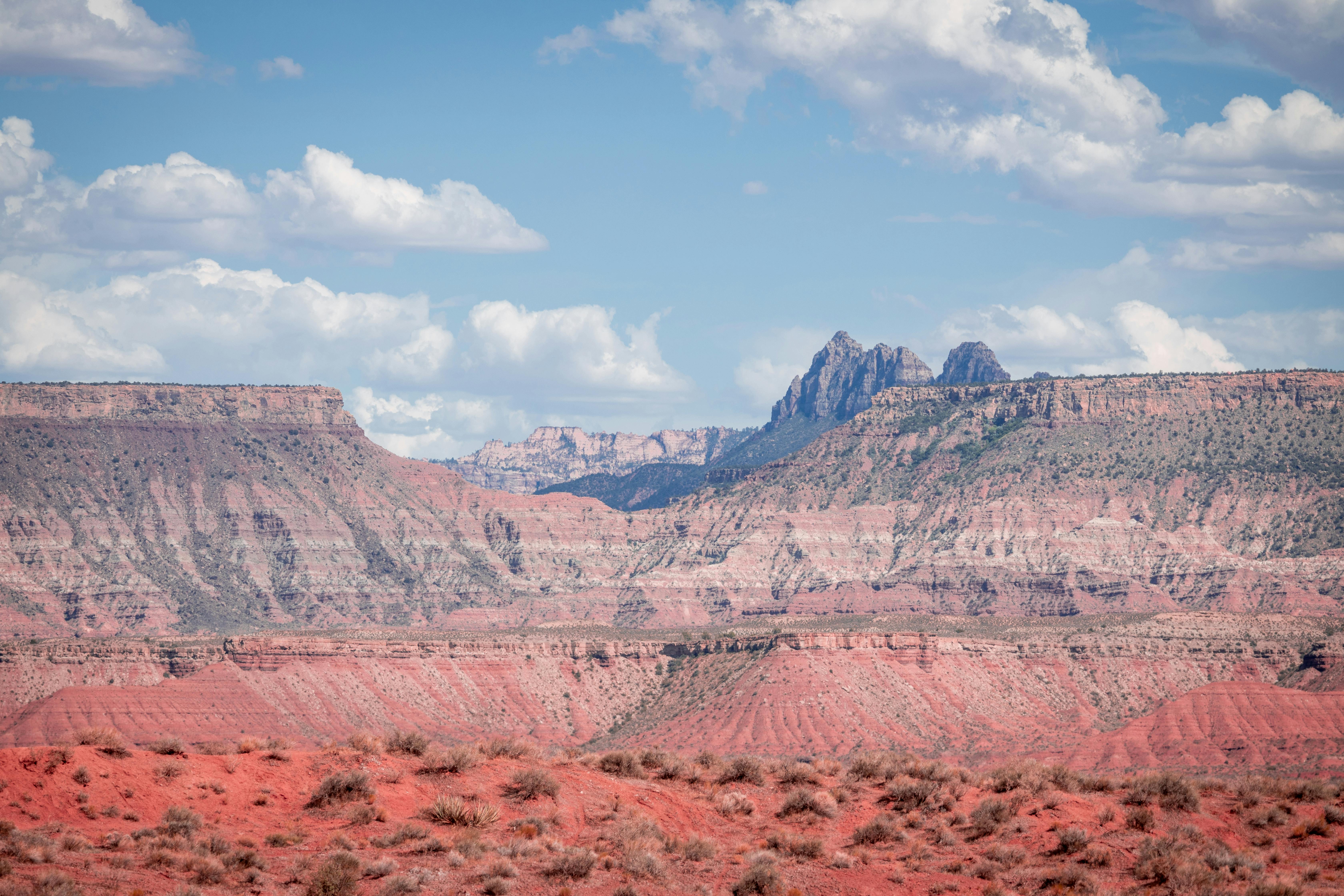 A red desert landscape with mountains in the background · Free Stock Photo