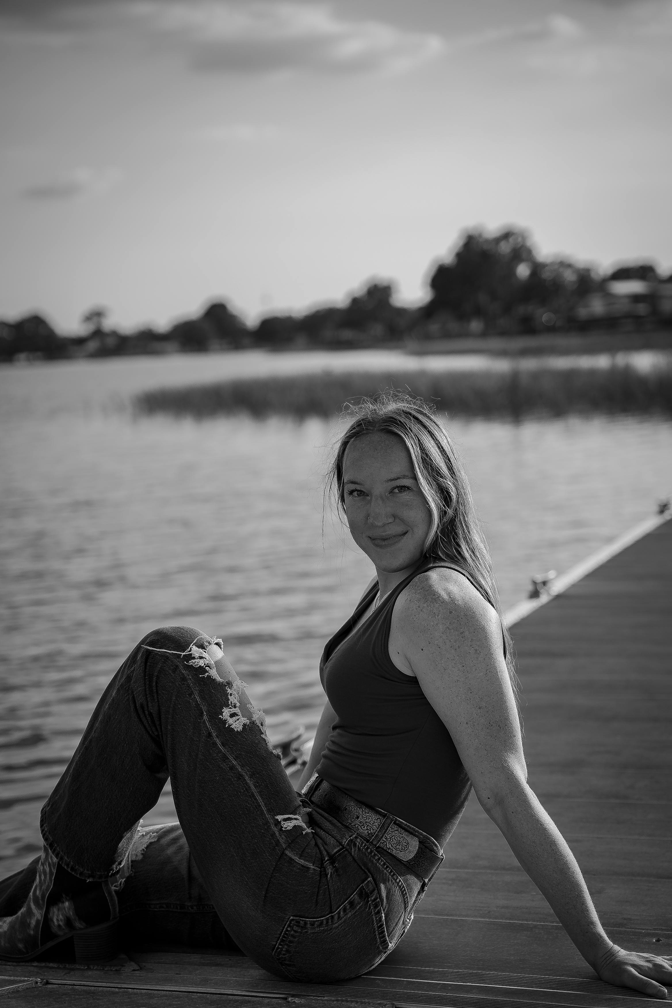 Woman Sitting on Pier and Posing by Water · Free Stock Photo