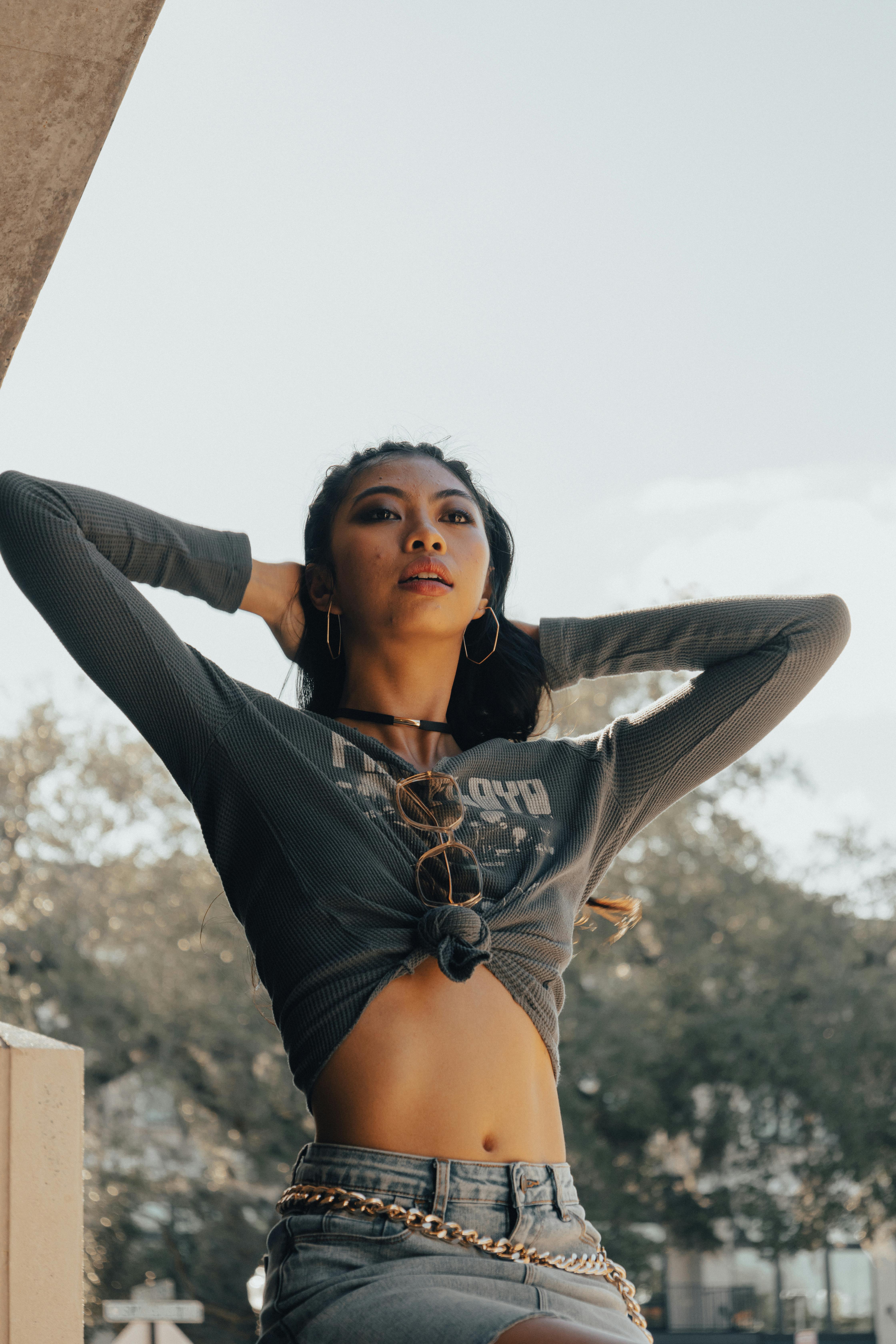 A woman in a crop top and jeans is posing for a photo · Free Stock Photo