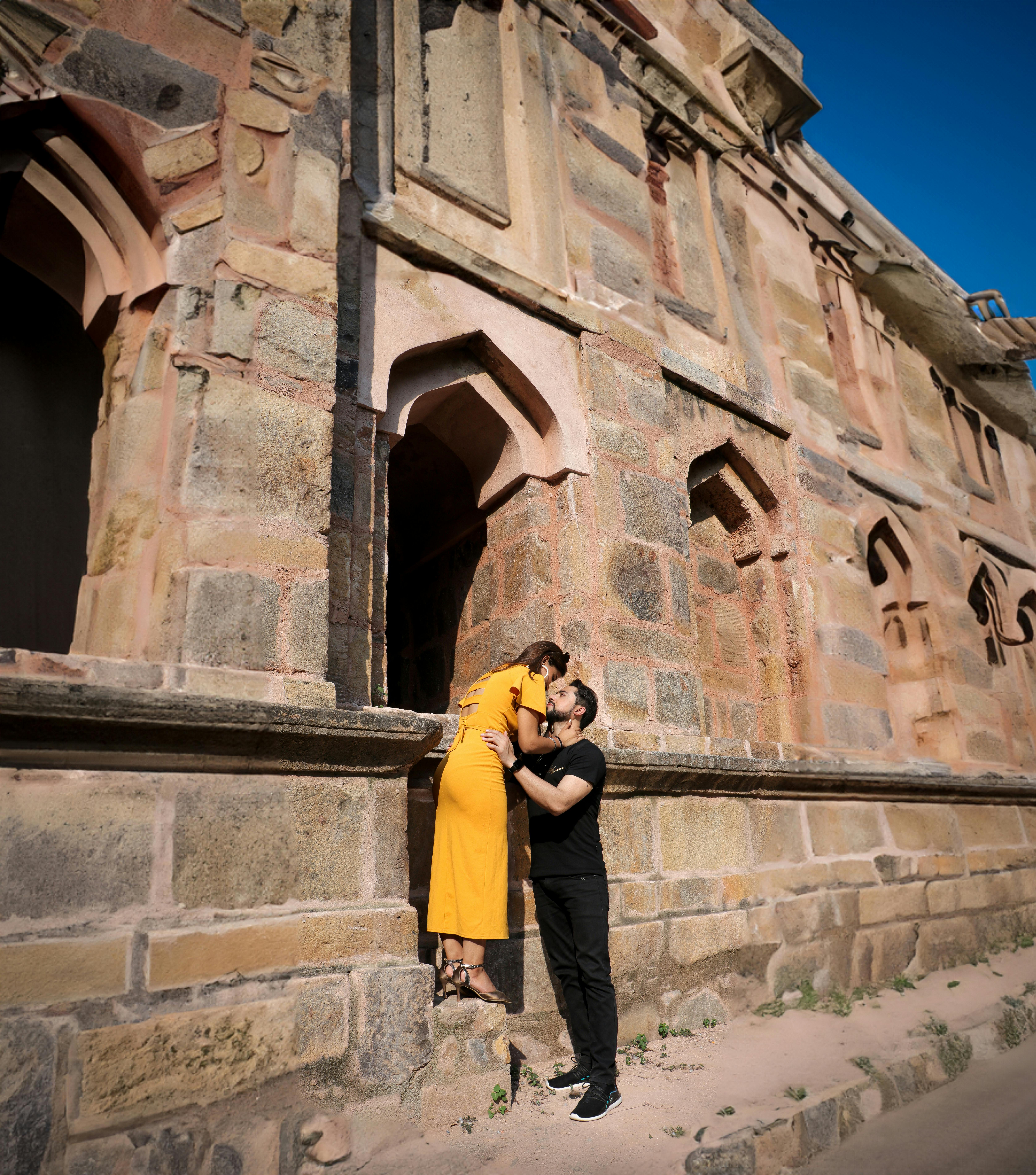 Couple Kissing by Sunlit Building Wall · Free Stock Photo