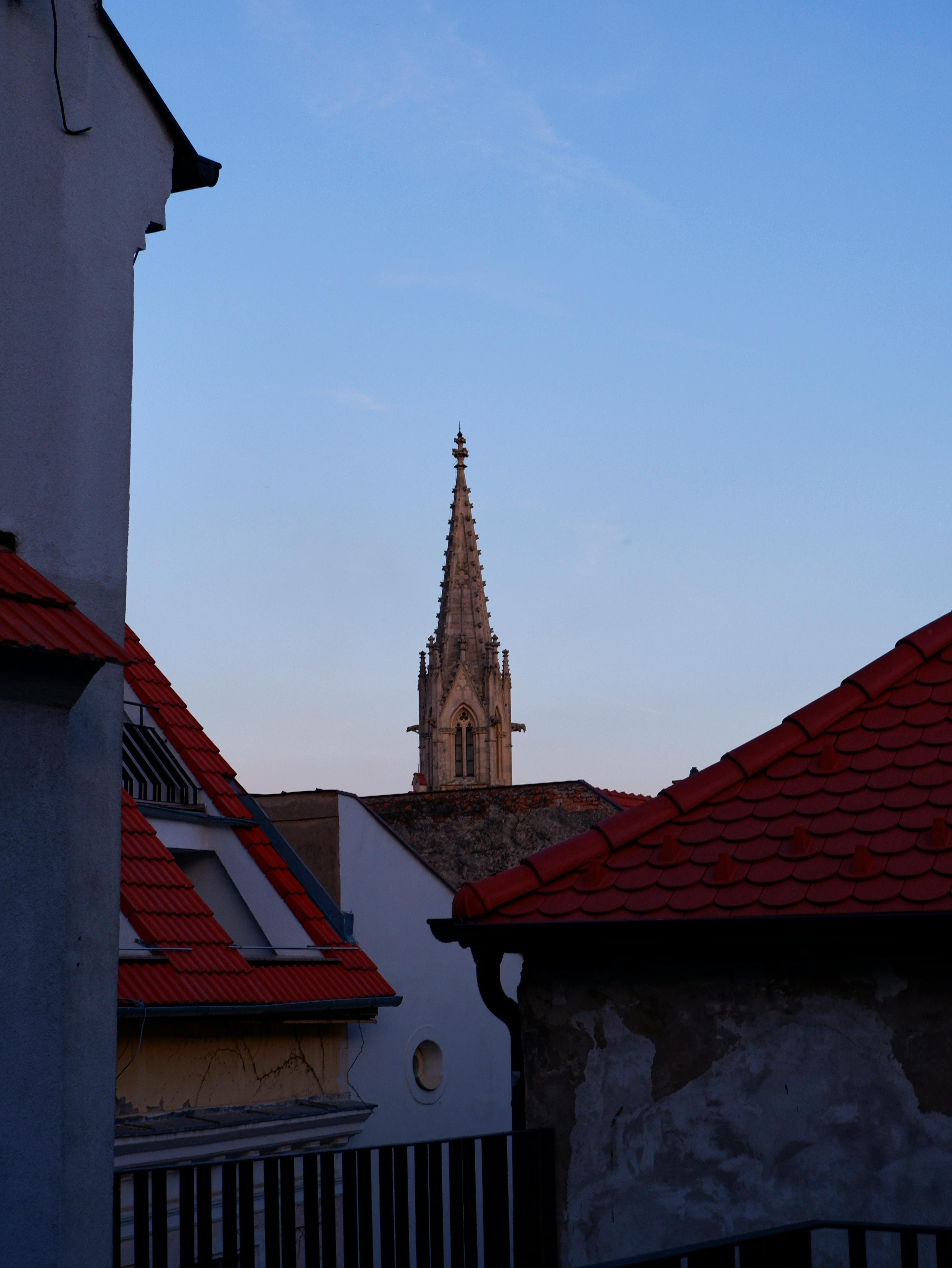 Gothic Church Tower over Rooftops · Free Stock Photo