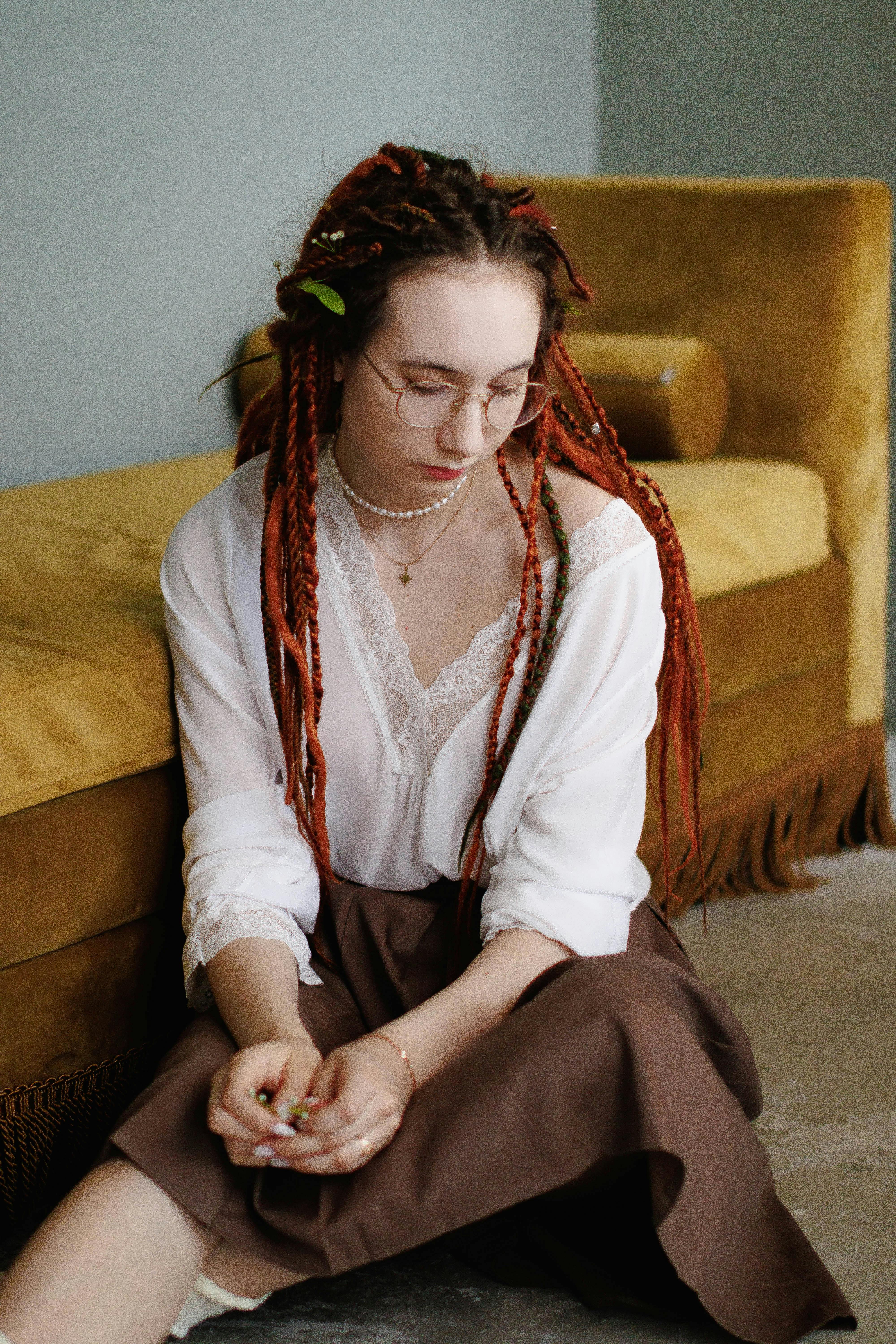 Young Woman with Dyed Dreadlocks Sitting on the Floor in White Blouse ...