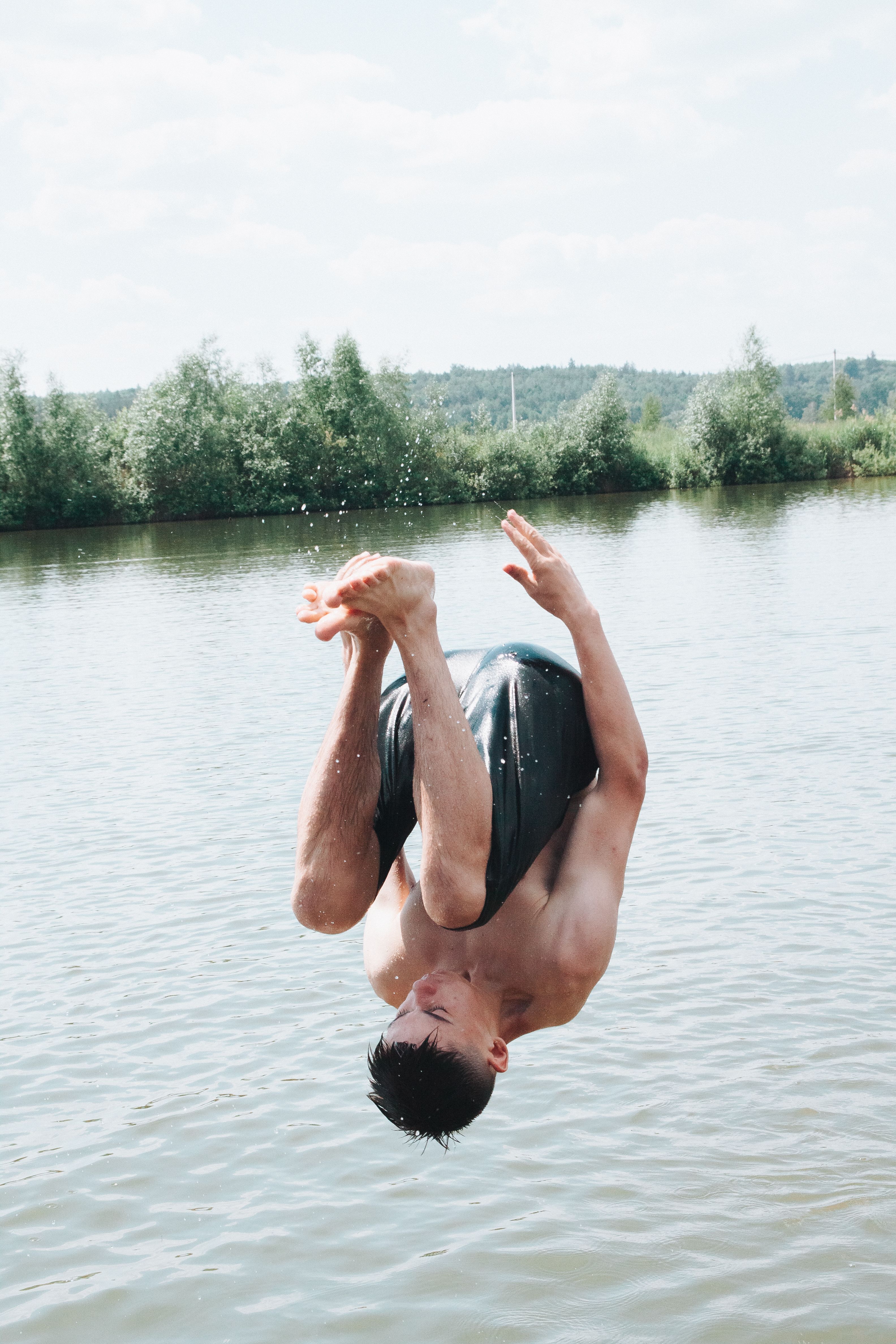 Young Man Making a Somersault Jump into River · Free Stock Photo