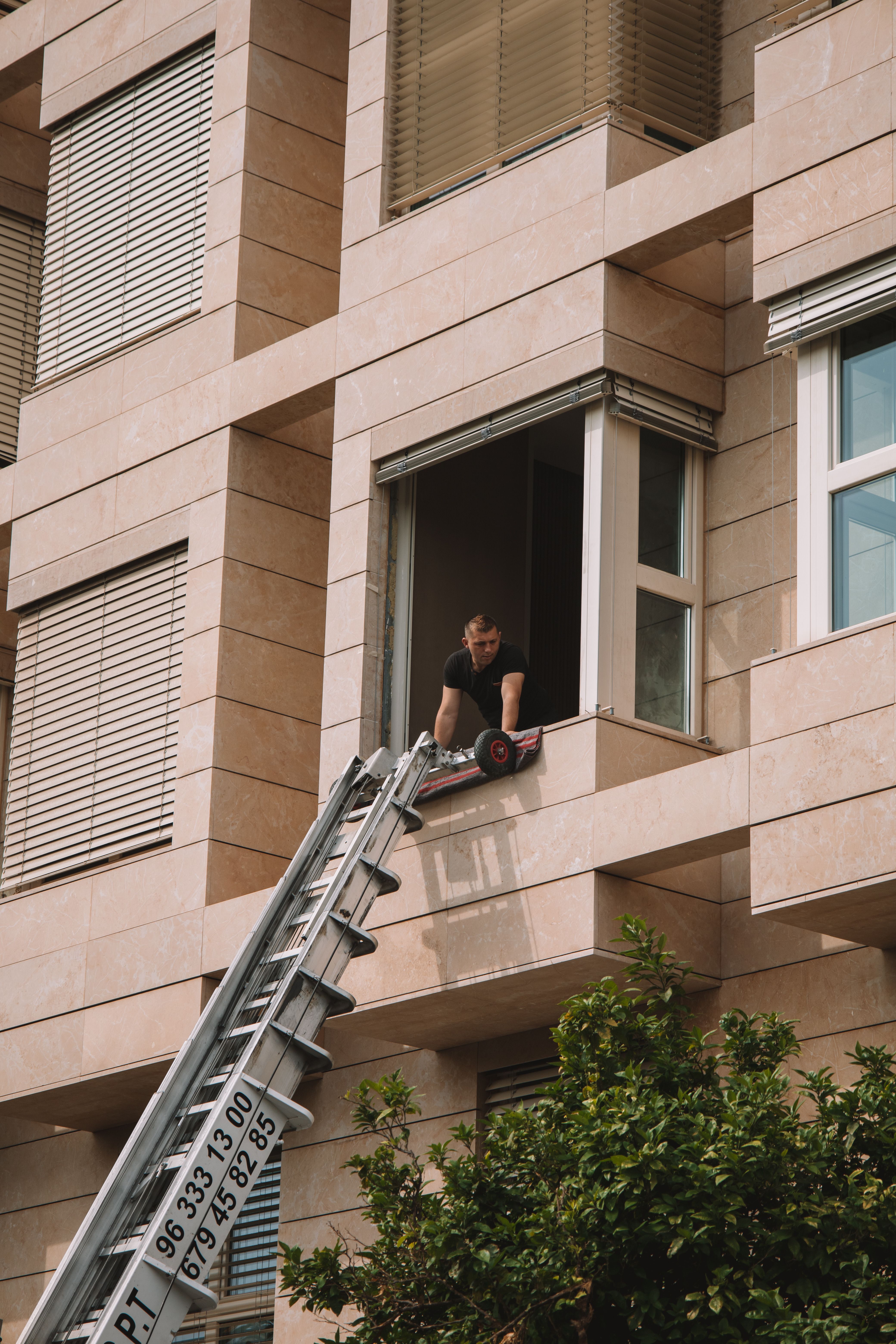 Man Standing in a Balcony of and Apartment Block with a Telescopic ...