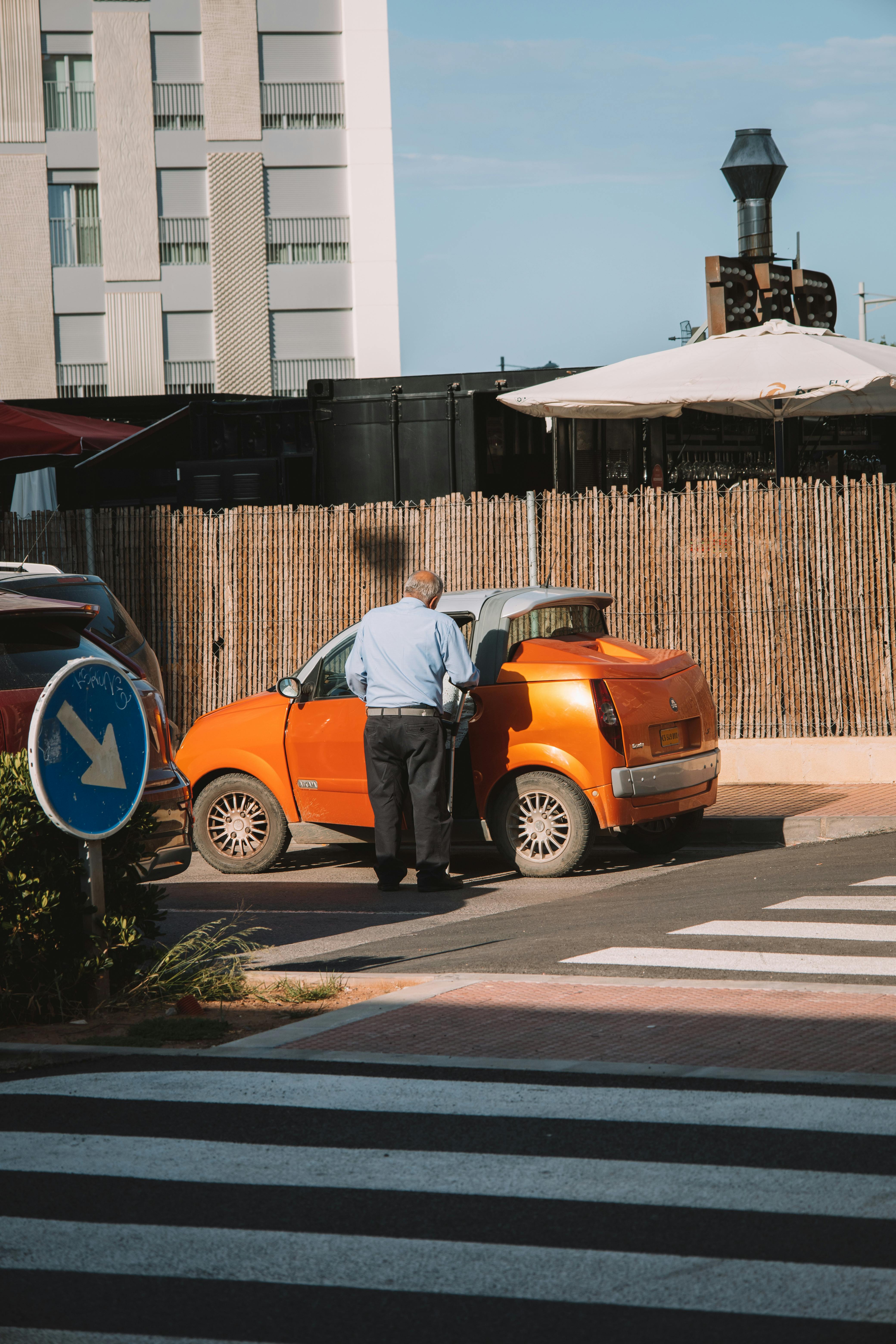 Man Getting into a Car in a City Street · Free Stock Photo