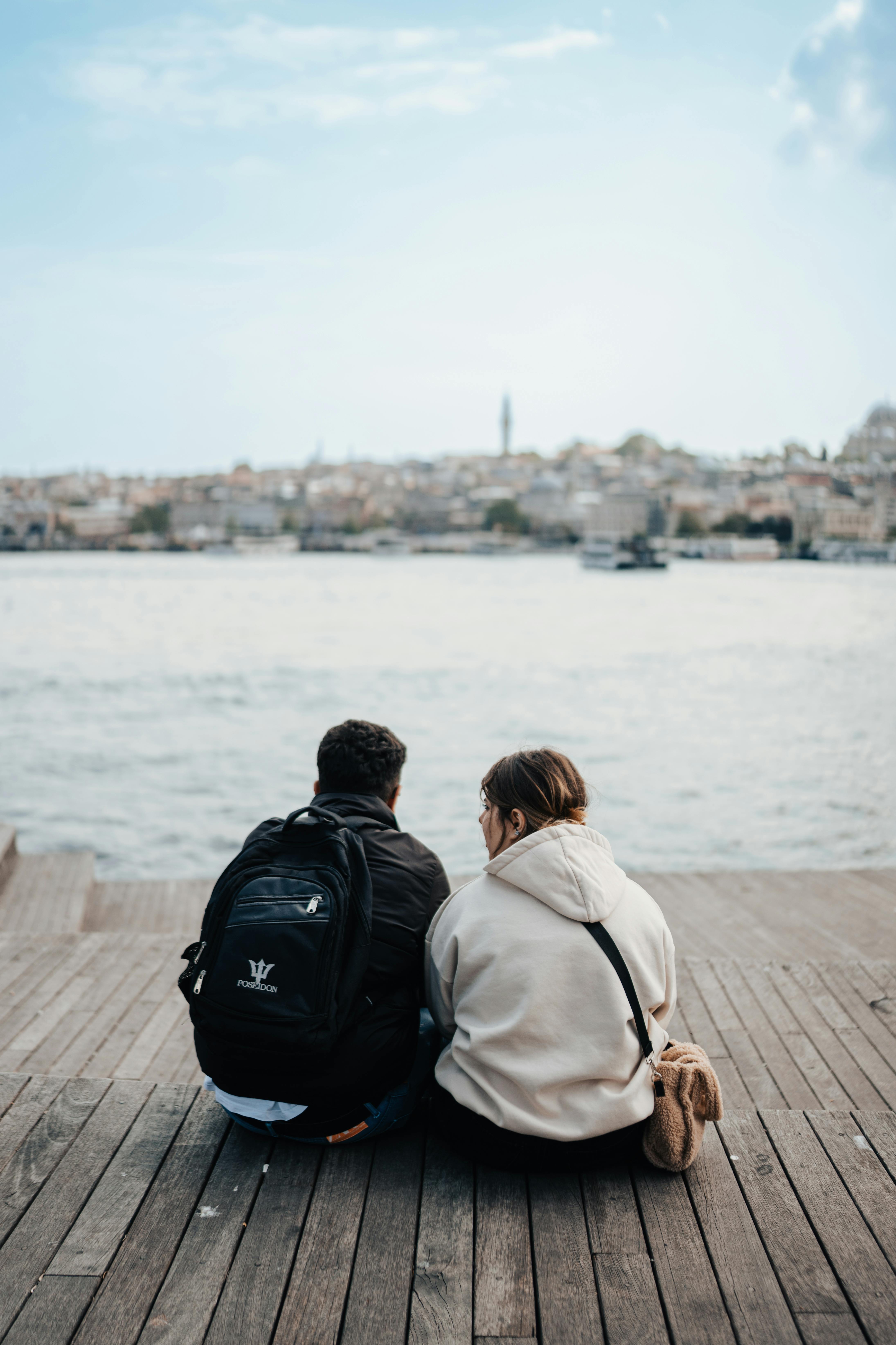 Young Couple Sitting Back to Back · Free Stock Photo