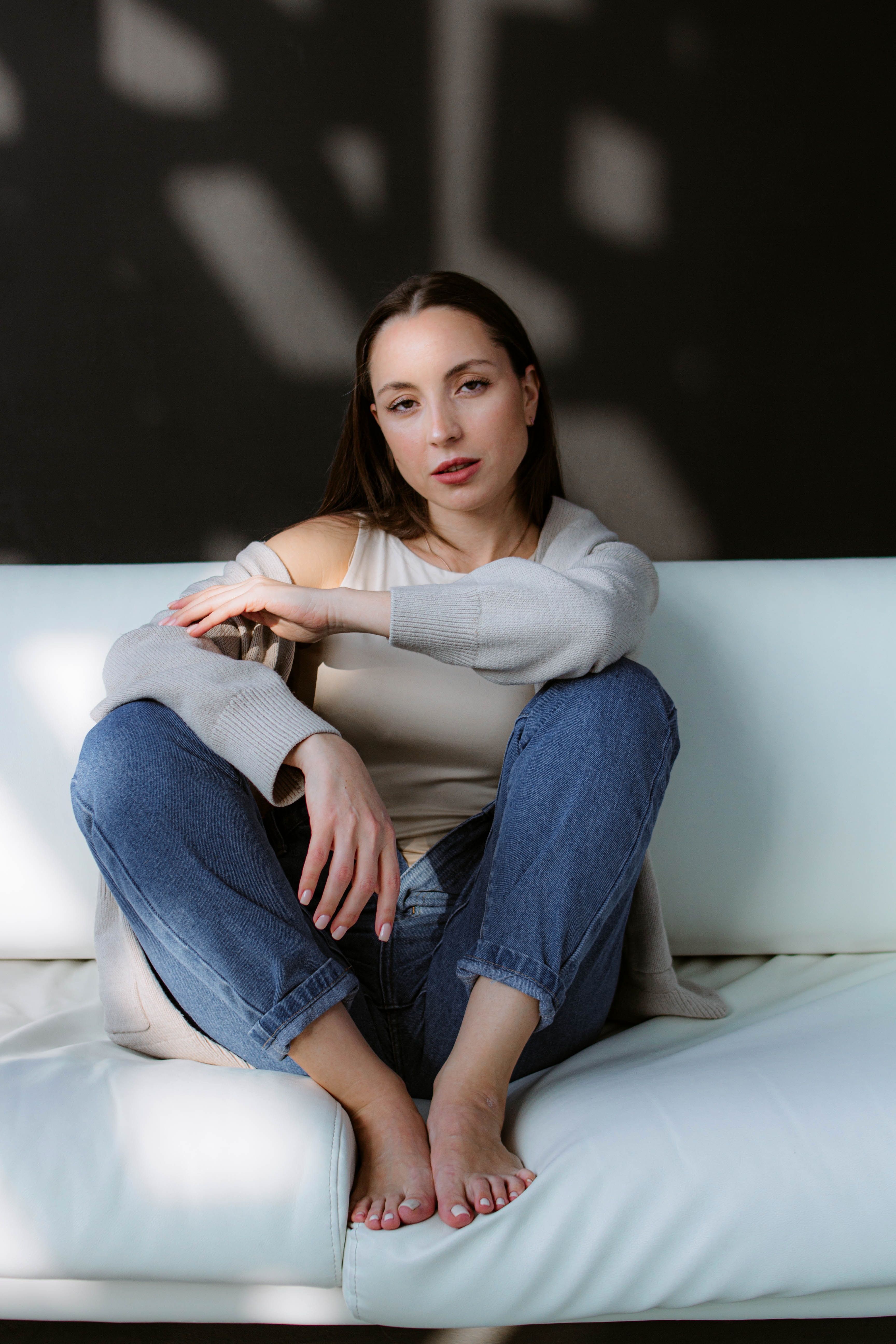 Woman in Black Tank Top Sitting on a Couch · Free Stock Photo