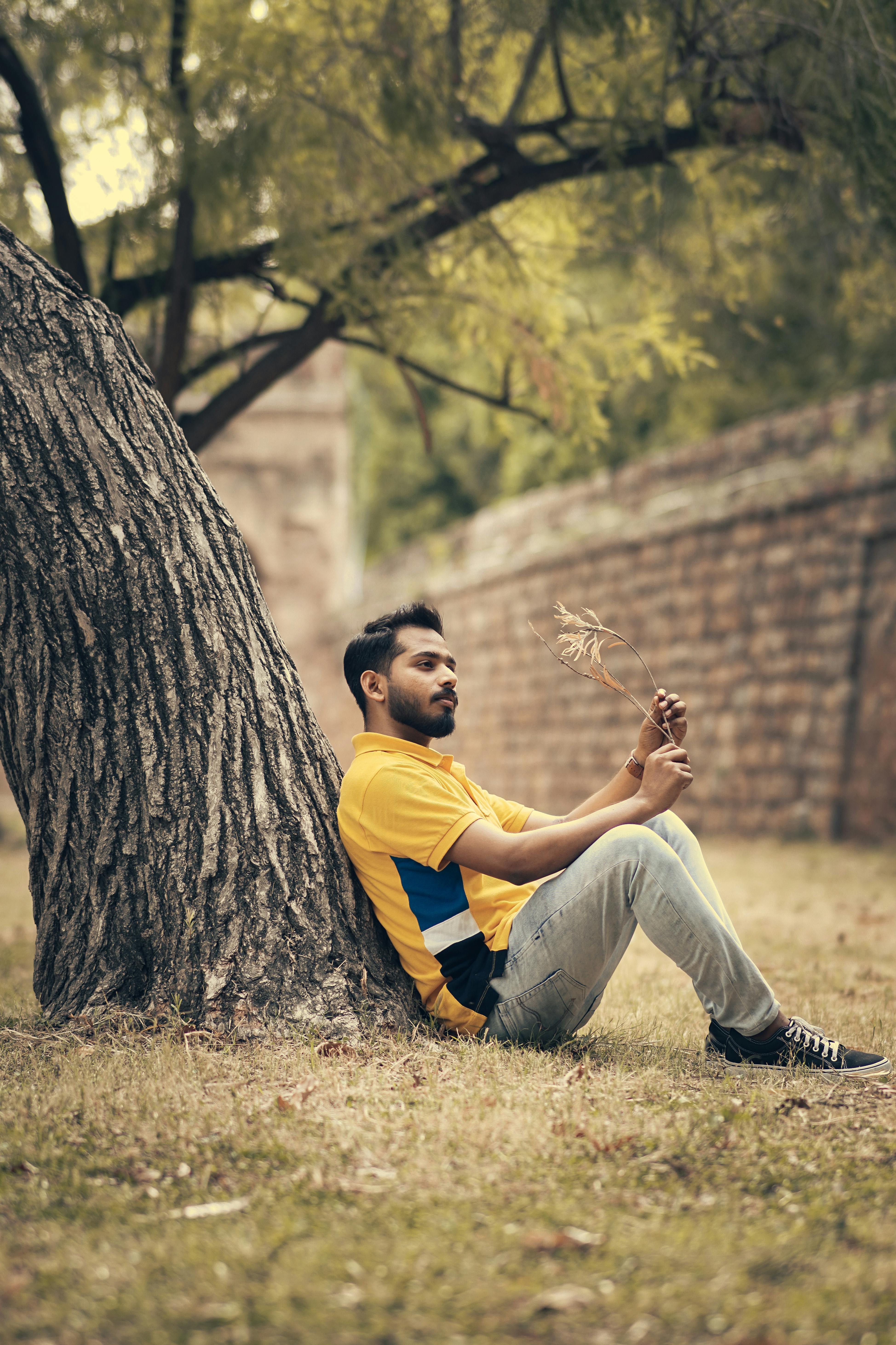 Man in Yellow Clothes Sitting by Tree · Free Stock Photo