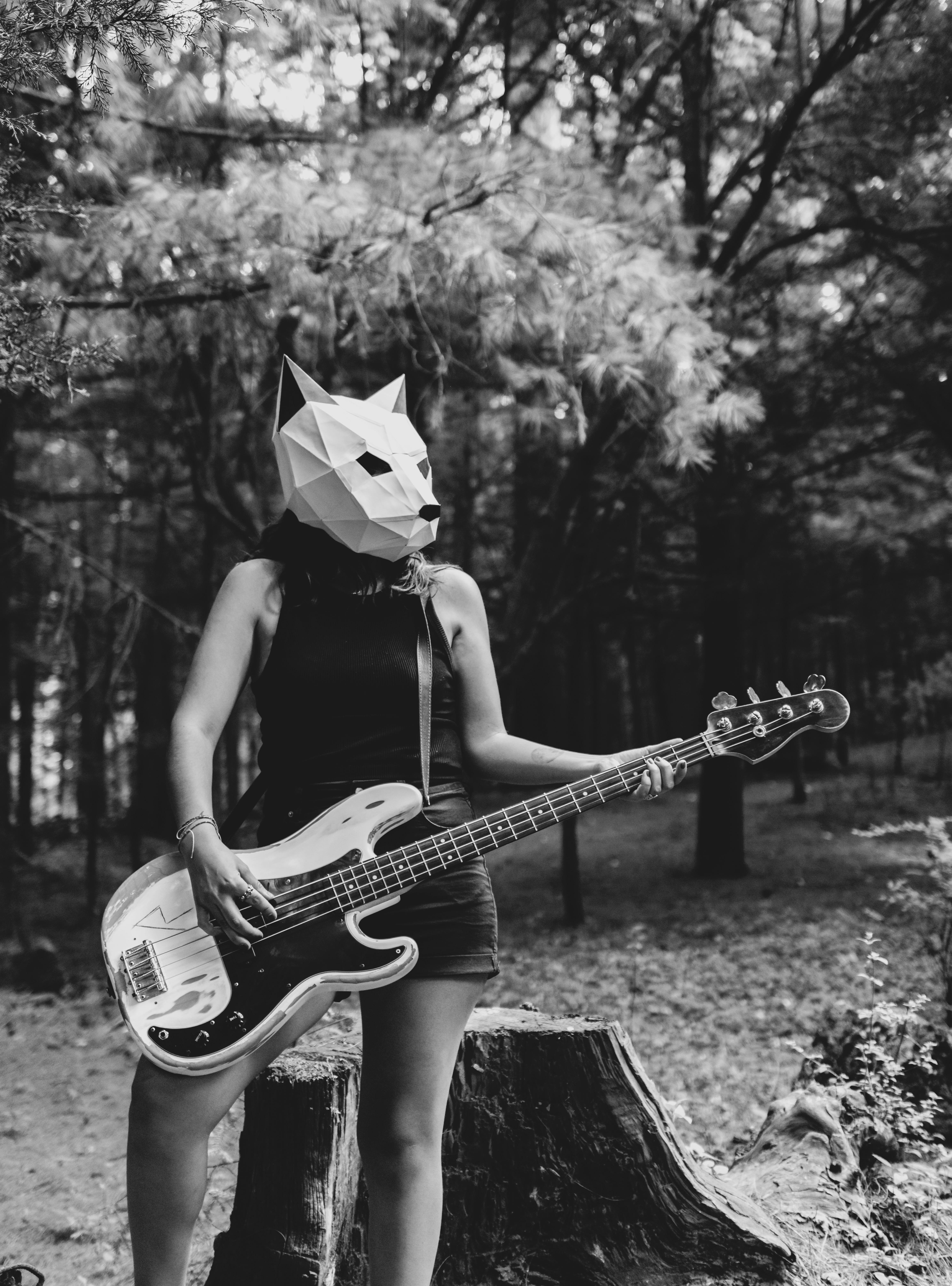 A woman in a mask playing a bass guitar · Free Stock Photo