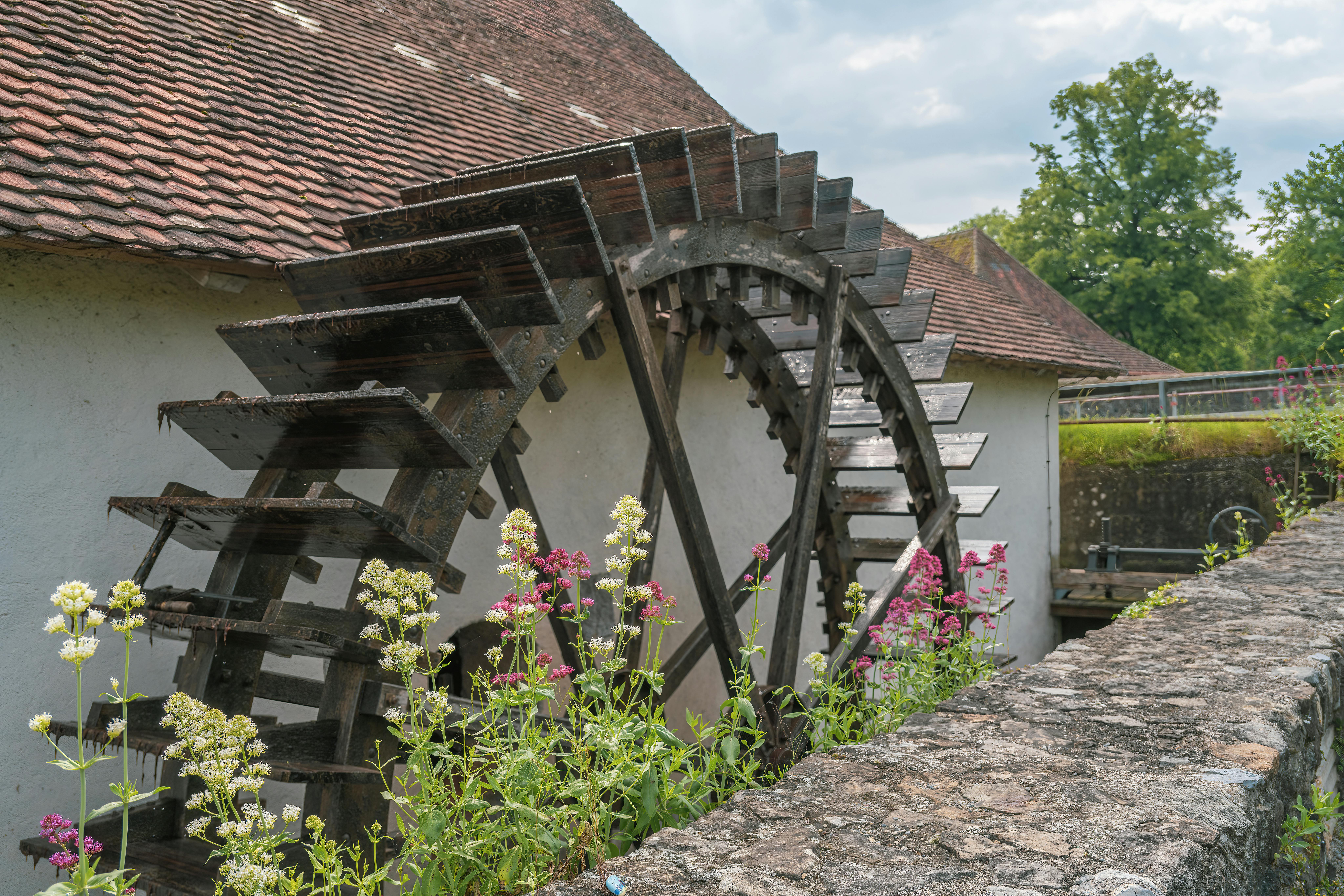 Watermill near Building Wall · Free Stock Photo