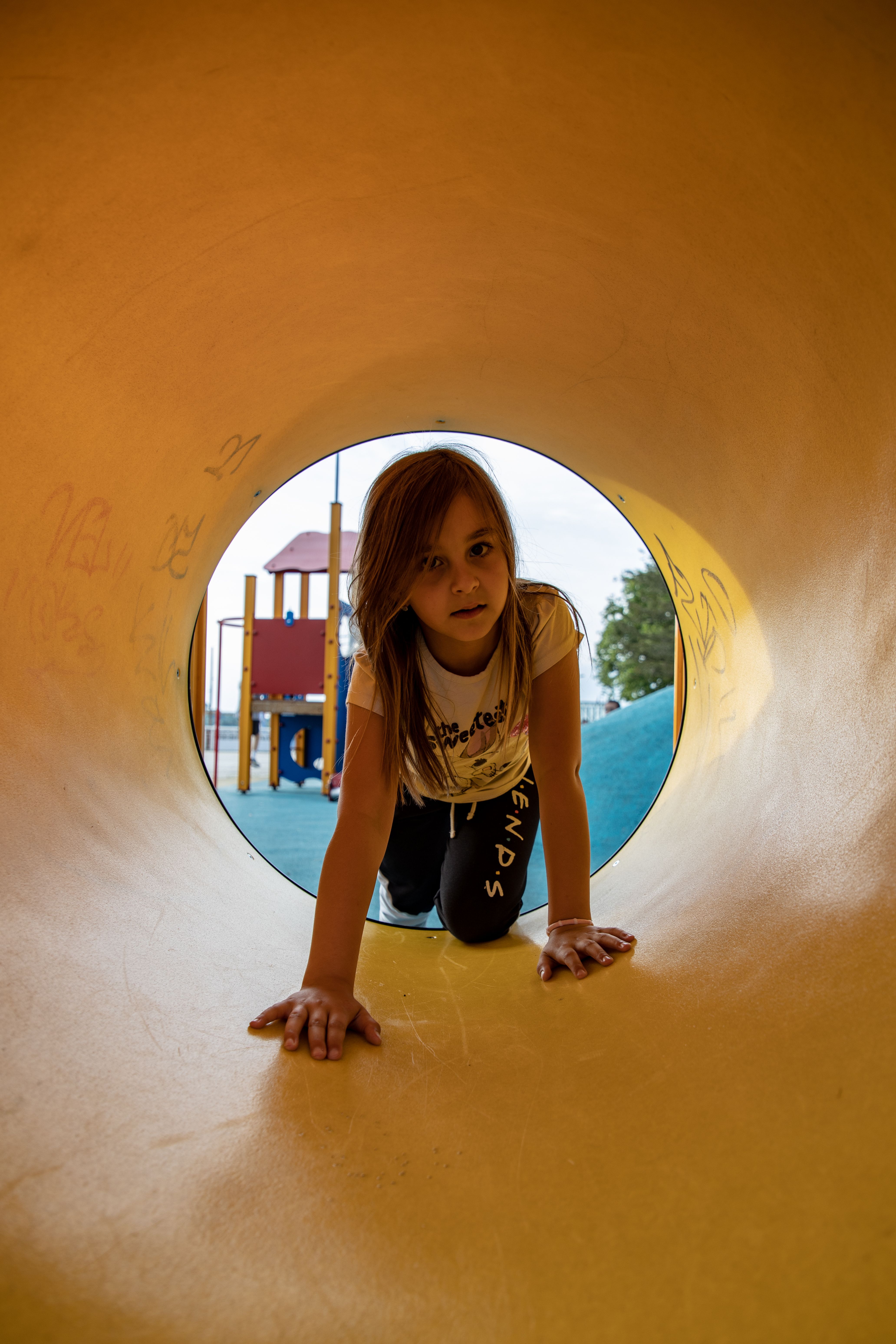 Little Kid Entering the Pipe on the Playground · Free Stock Photo