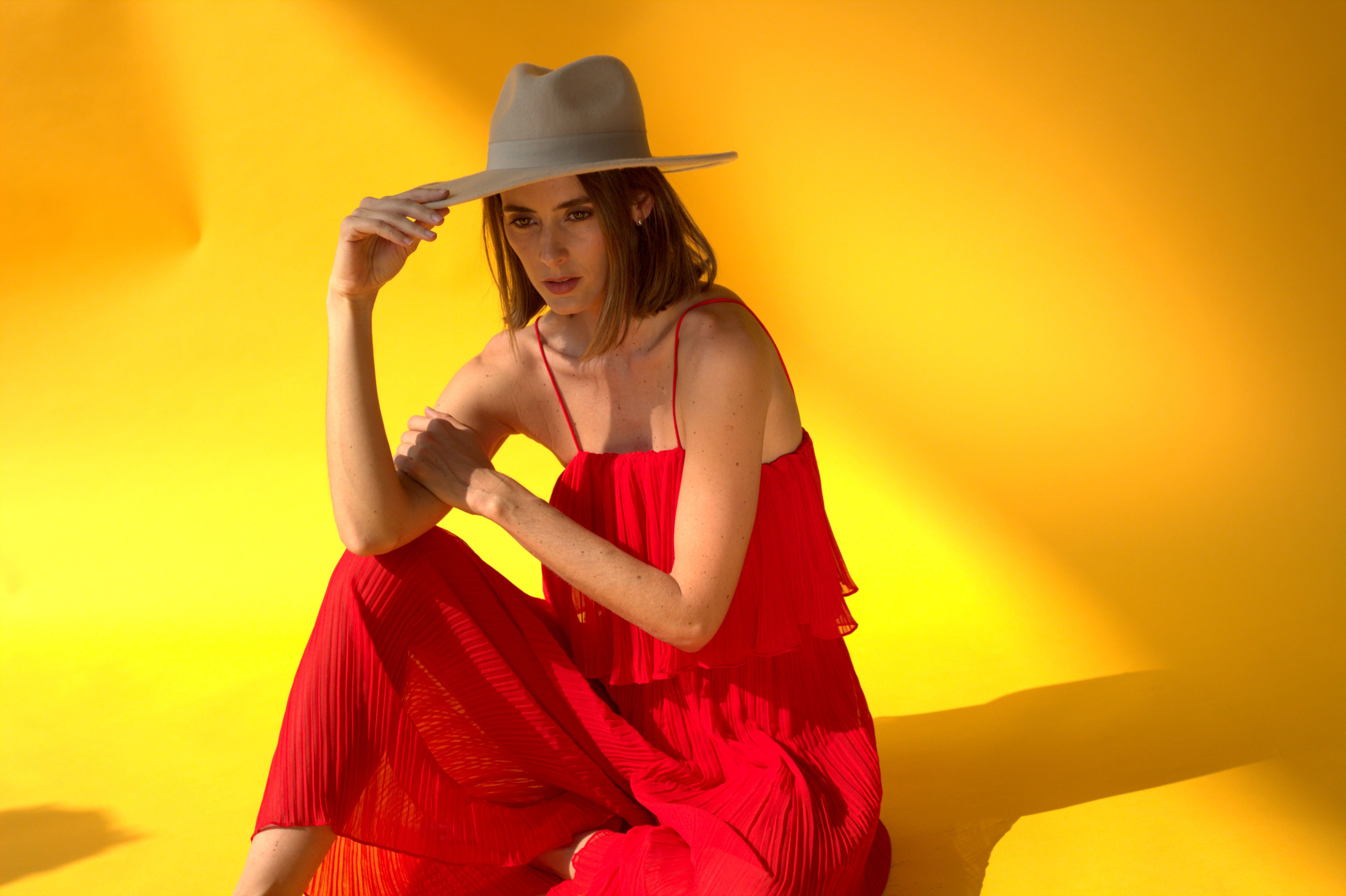 Woman Wearing Red Sundress and Hat Sitting on Yellow Surface · Free ...