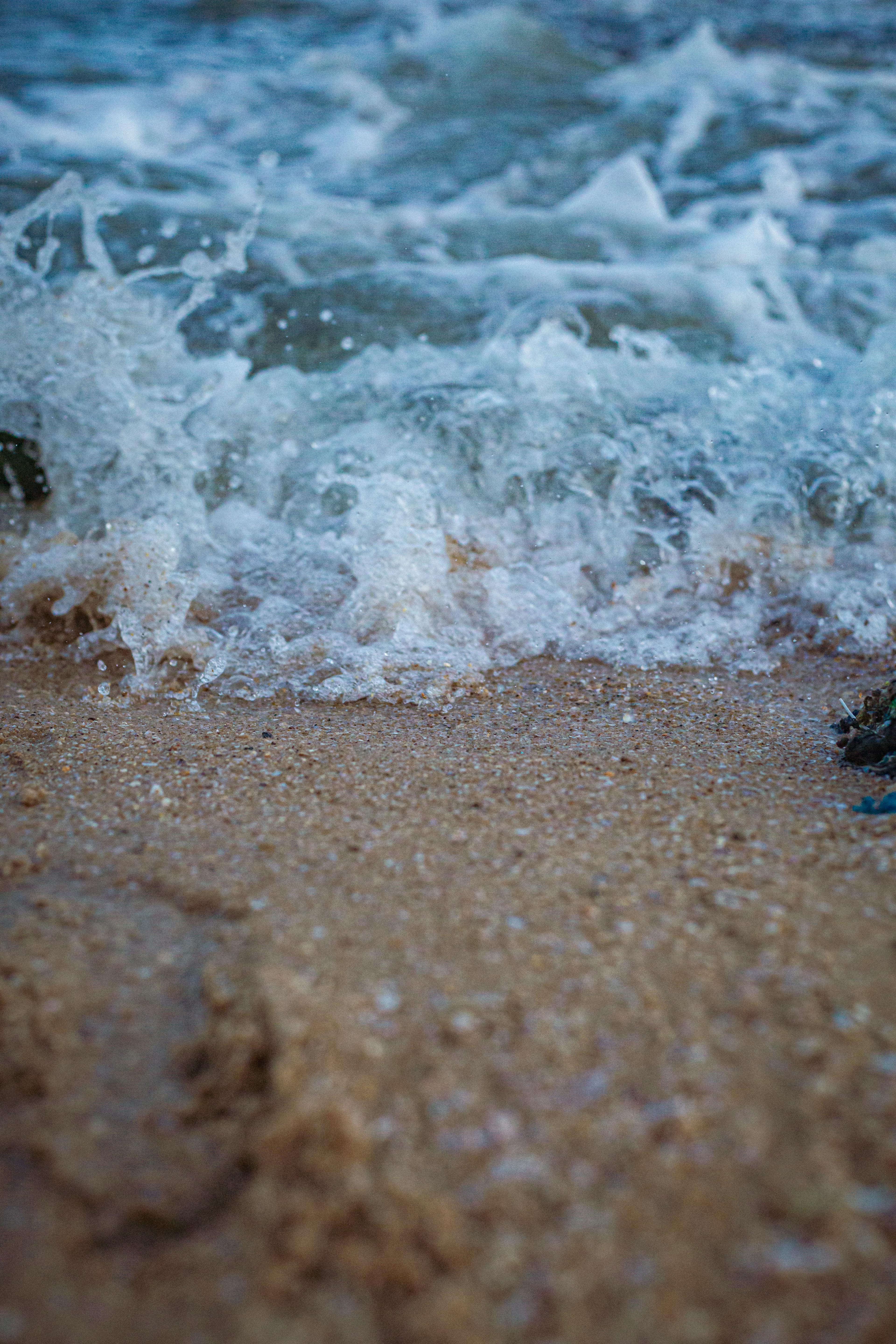 A close up of waves crashing on the beach · Free Stock Photo