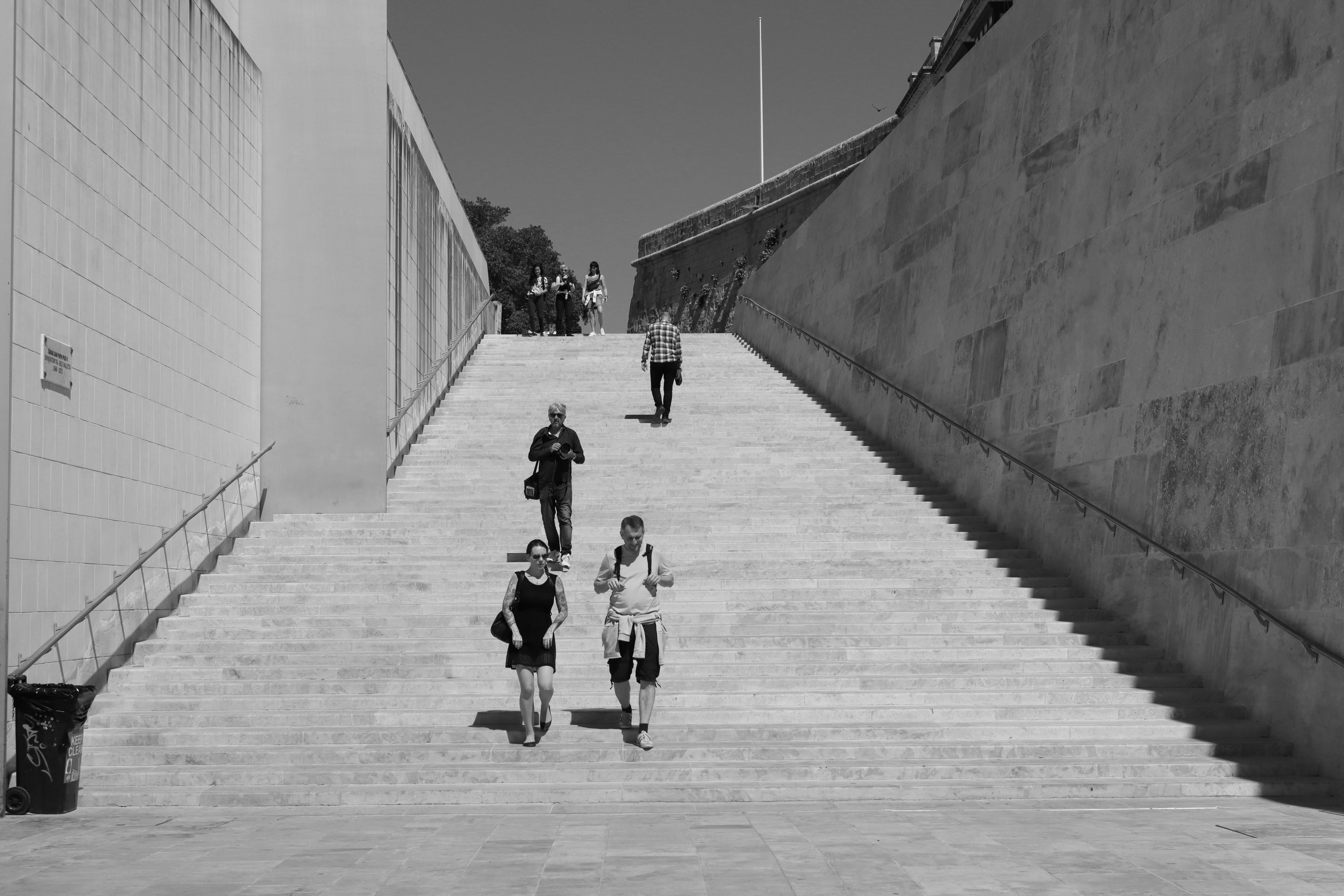 Black and White Photo of People Walking on Large Stairs in Sunlight ...
