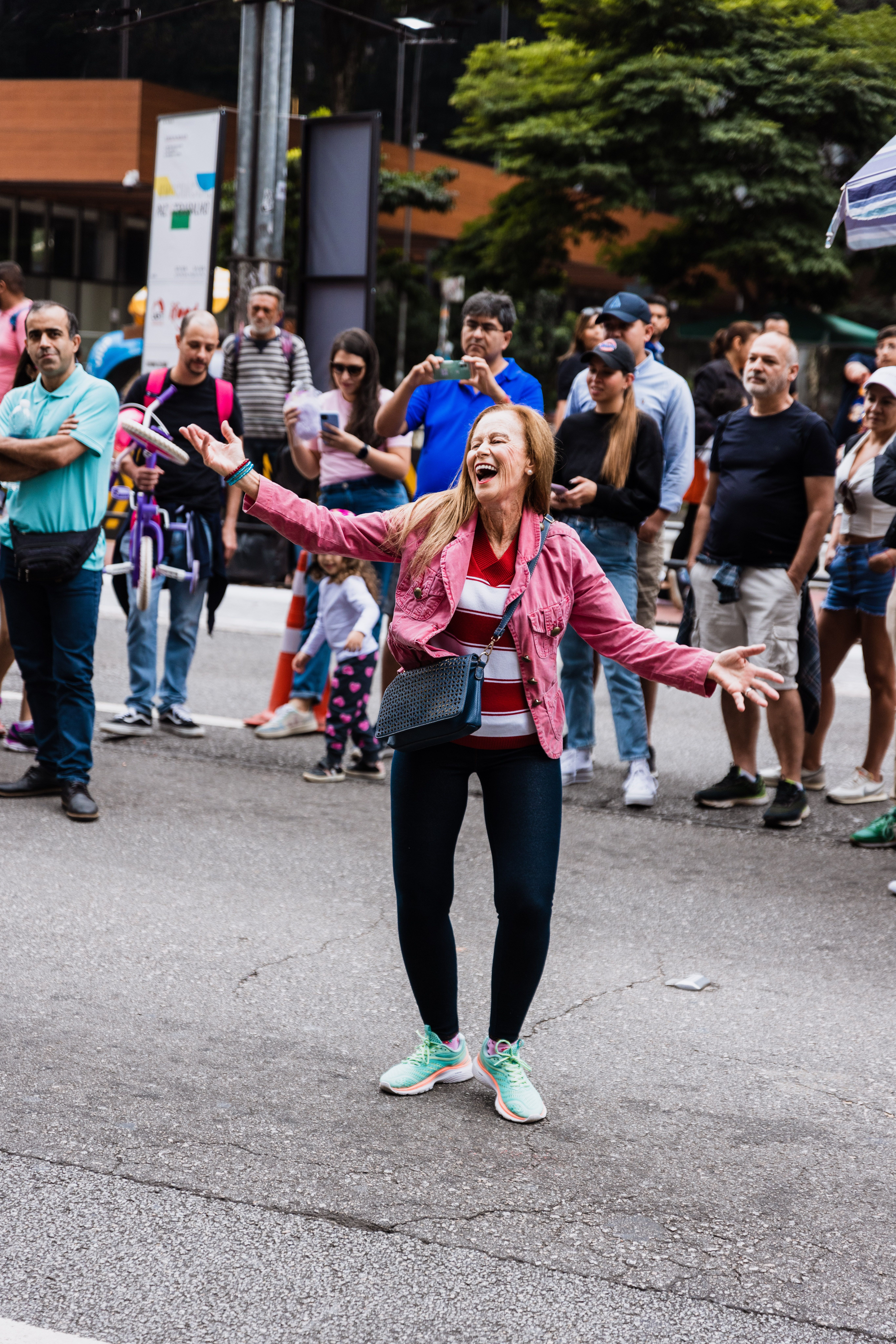 A Happy Woman Dancing on the Street in the Crowd · Free Stock Photo