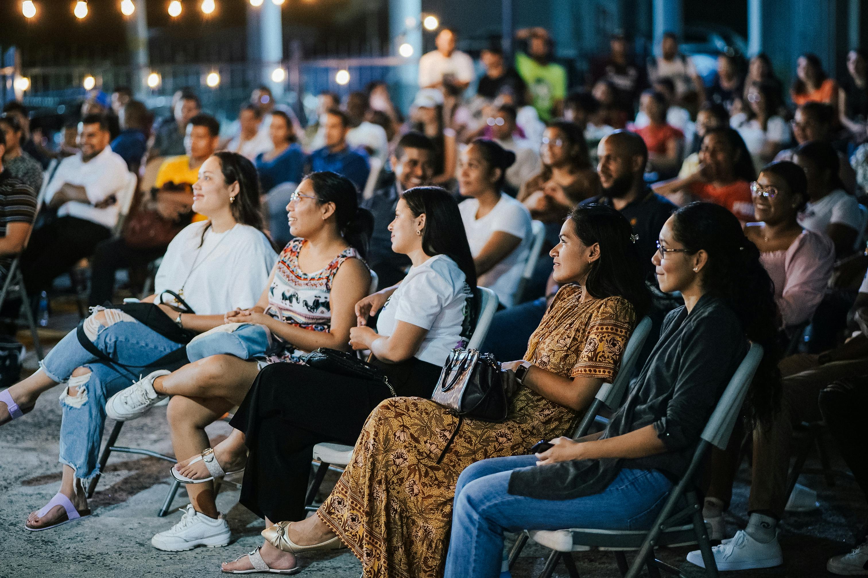 An Audience Sitting Outside in the Evening · Free Stock Photo