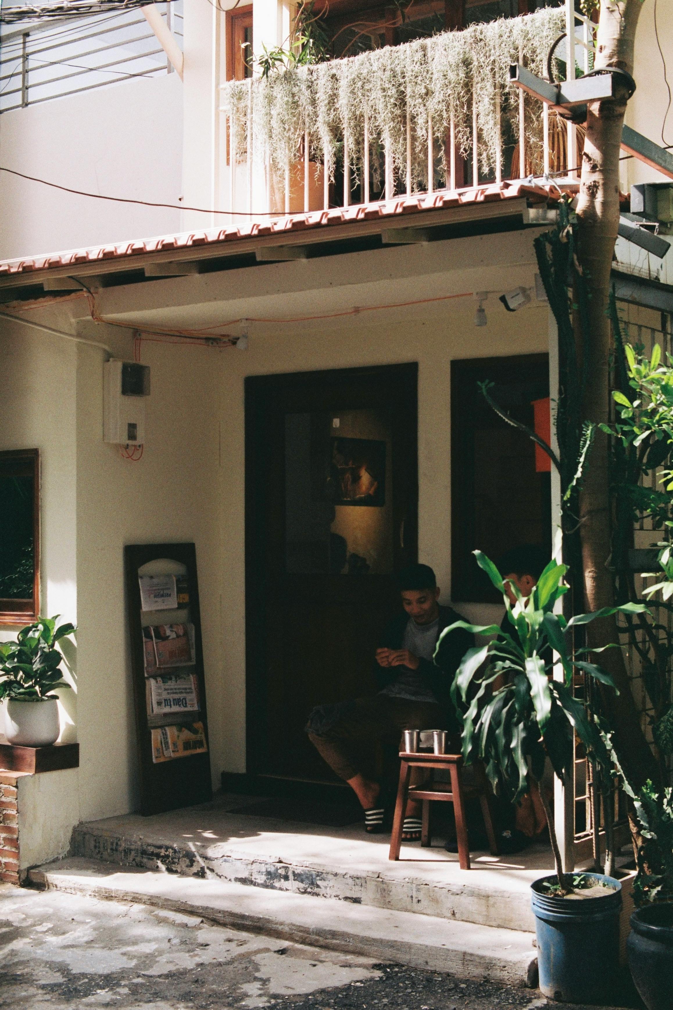 Person Sitting in Shadow in Building Entrance · Free Stock Photo