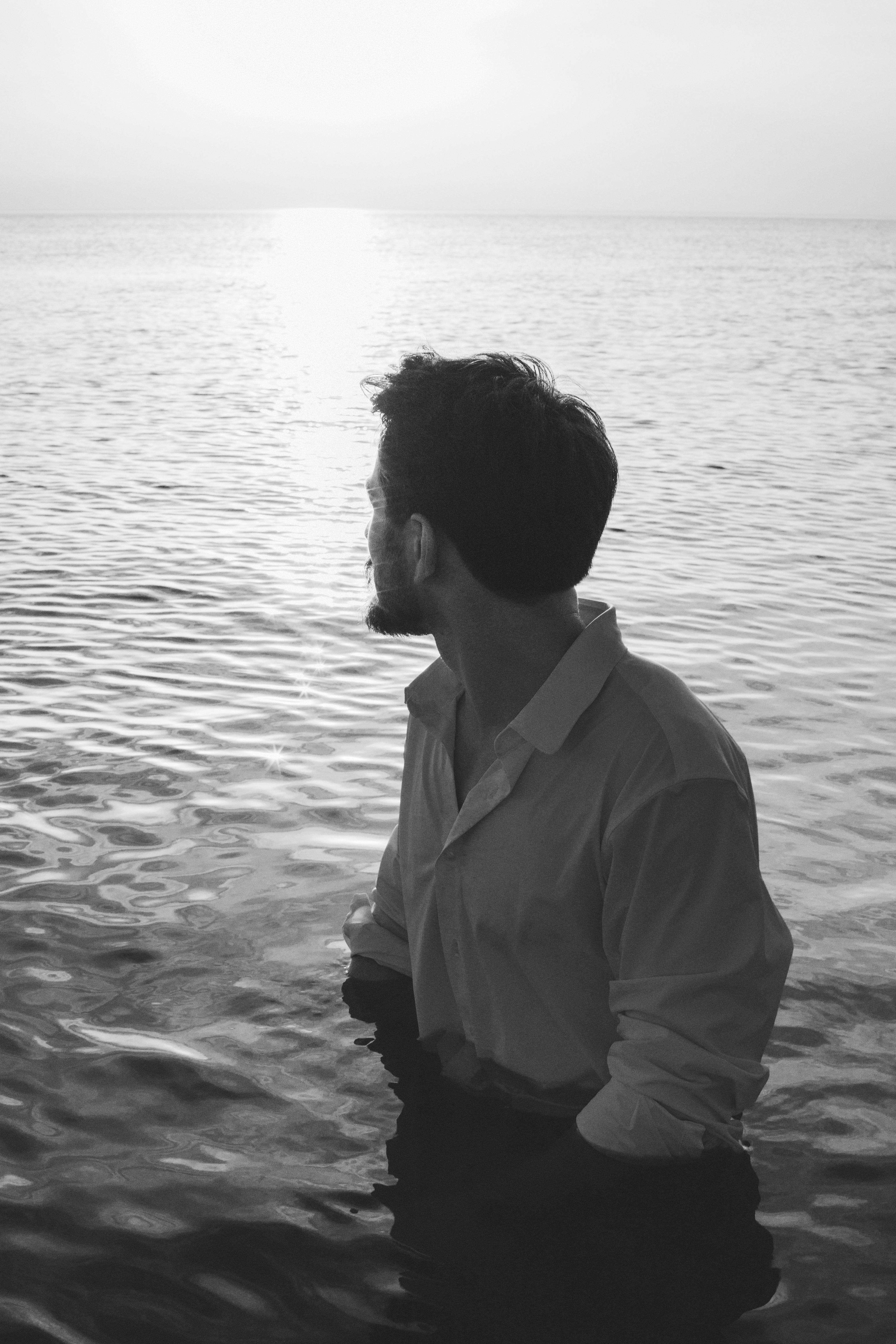 Sunlight over Man in Water in Black and White · Free Stock Photo