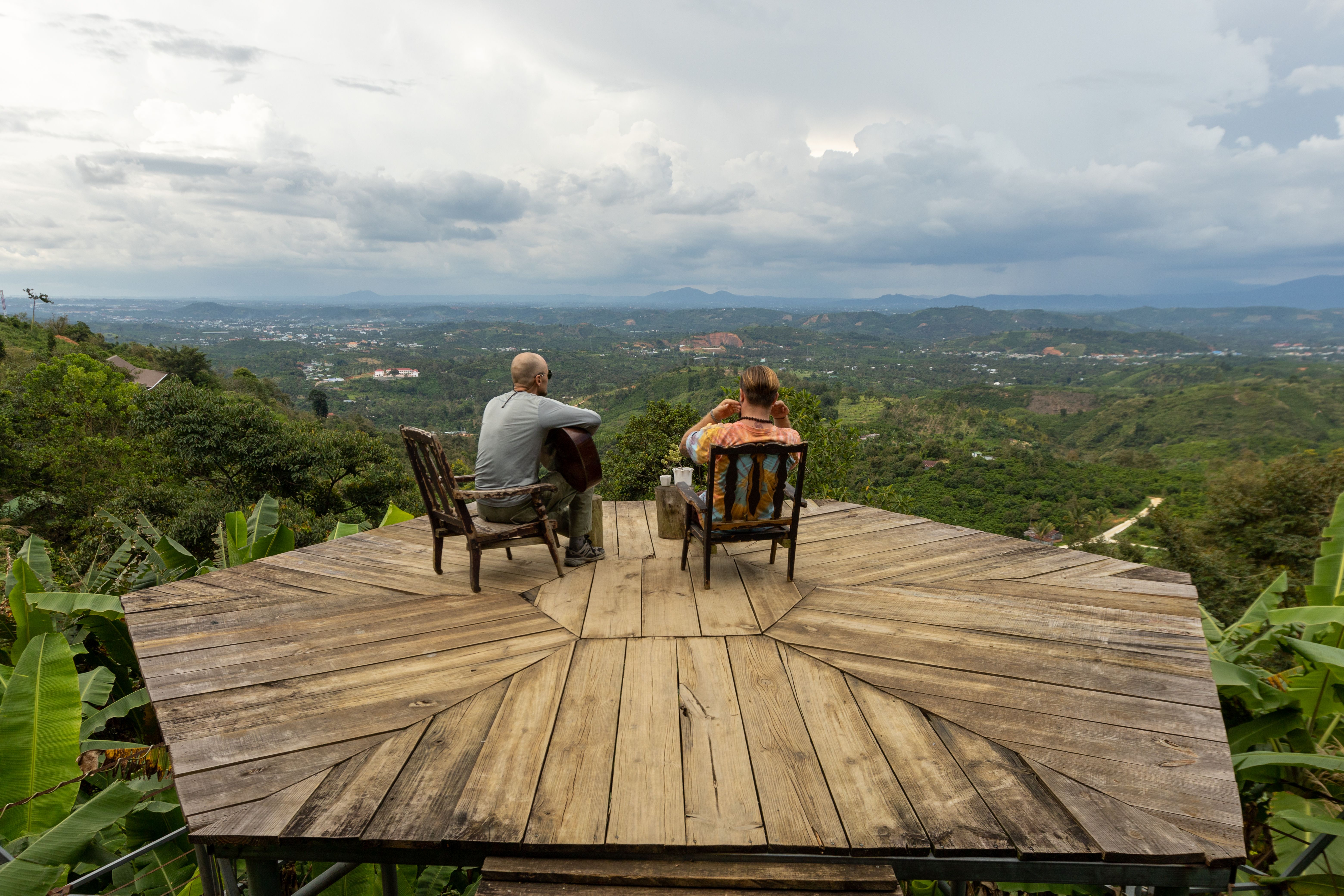 Men Sitting on Terrace over Forest and Playing Music · Free Stock Photo