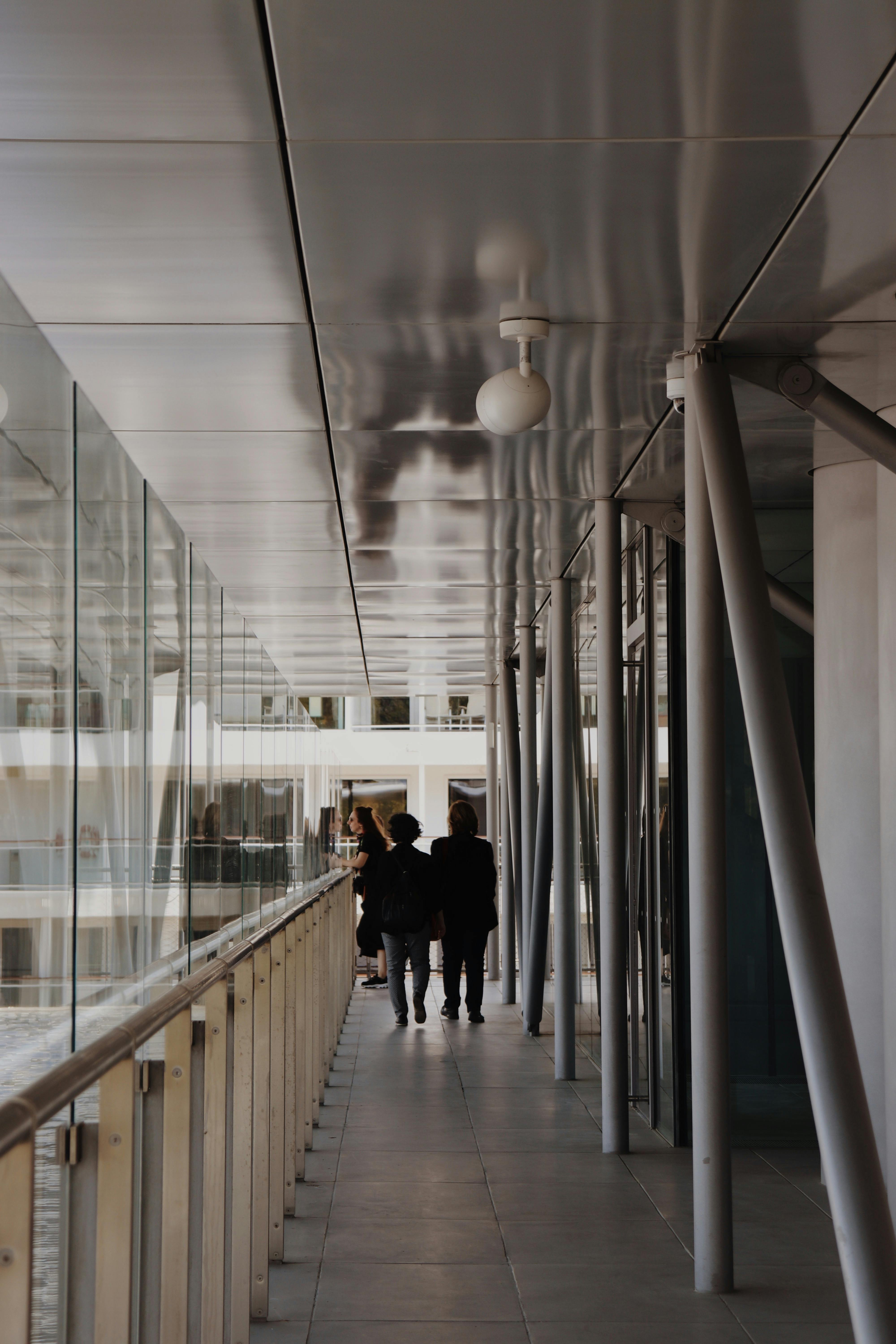 People Walking on Pavement near Railing · Free Stock Photo
